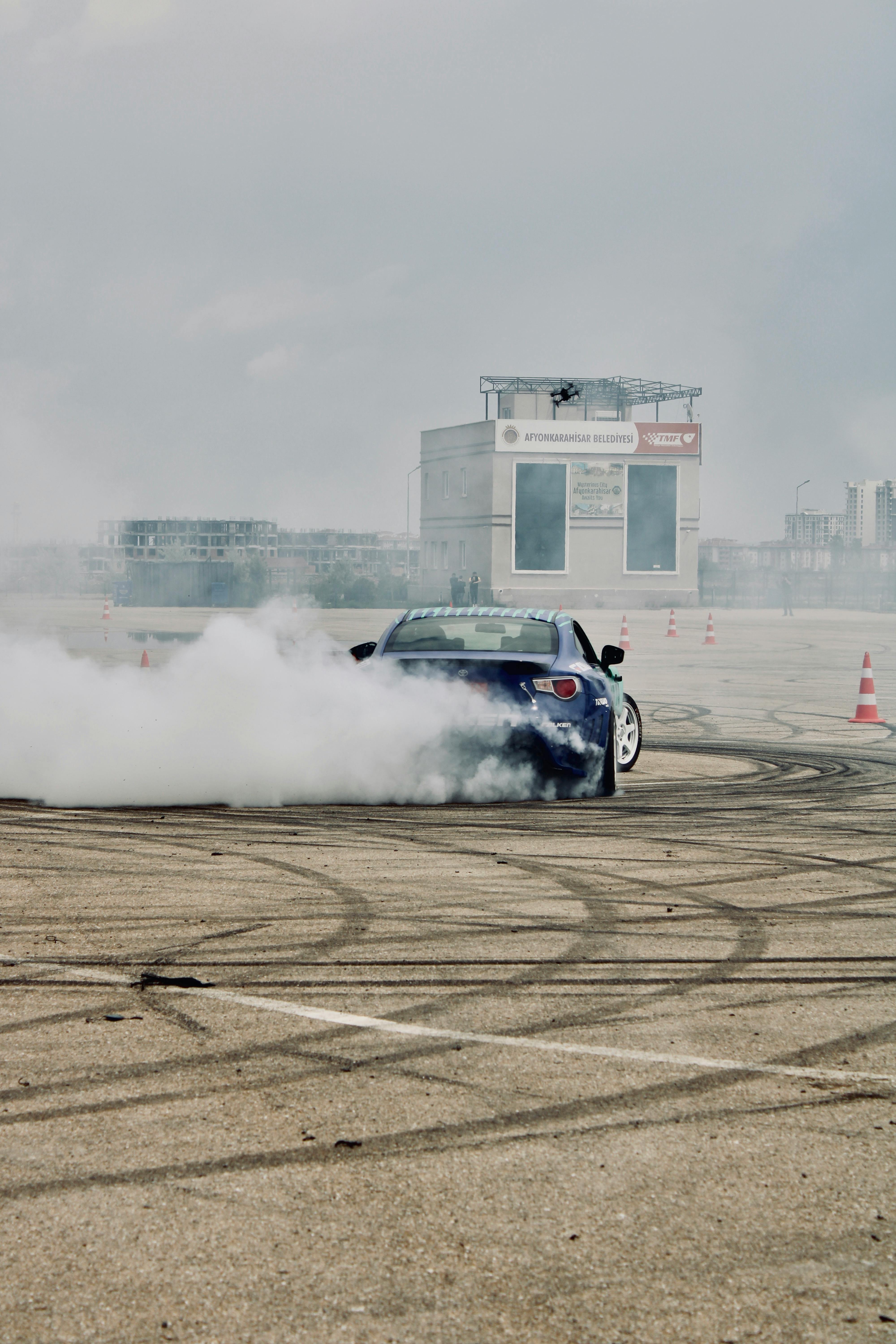 A car is drifting smoke in the air · Free Stock Photo