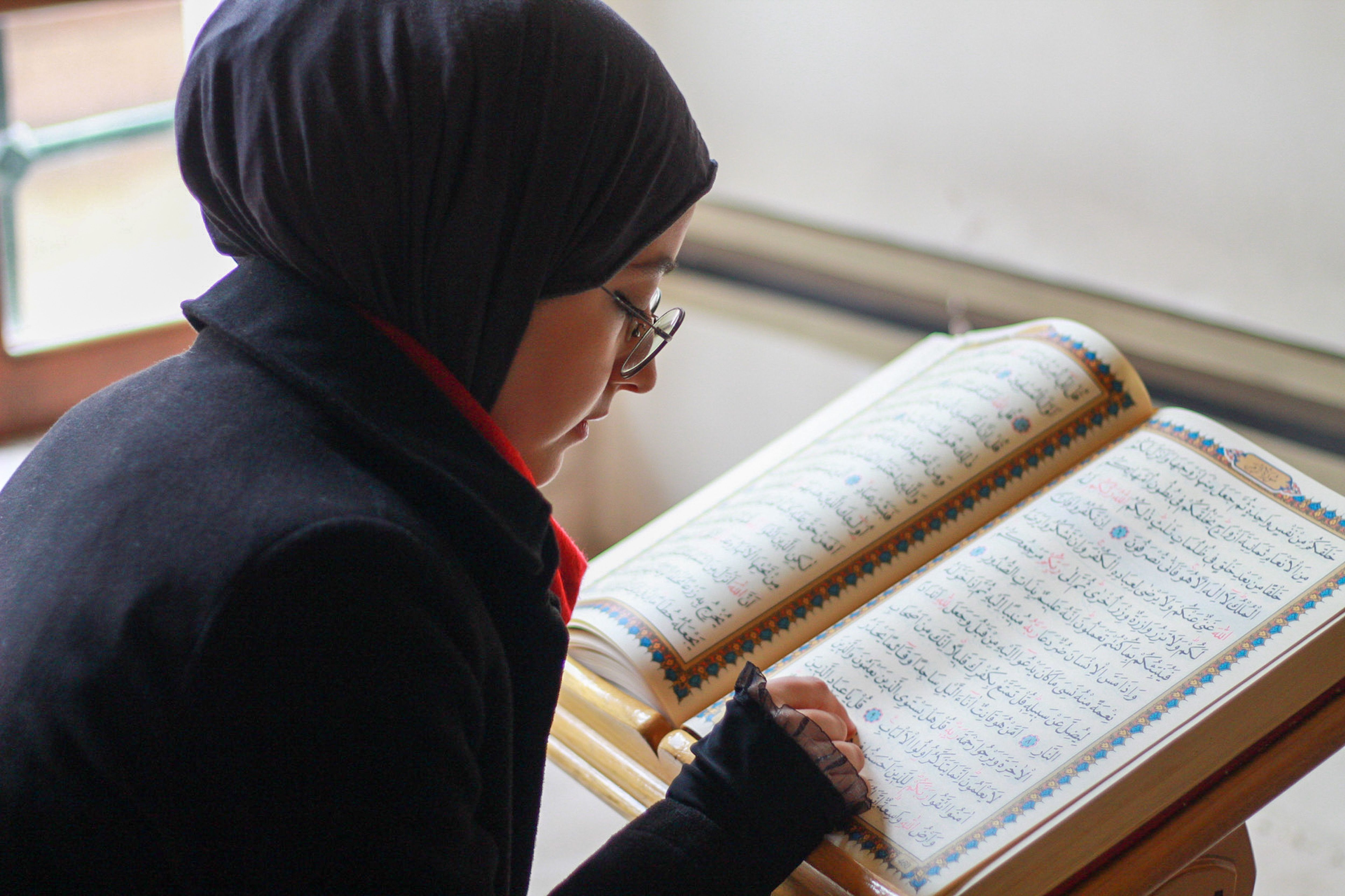 Woman in Black Hijab Reading a Sacred Book · Free Stock Photo