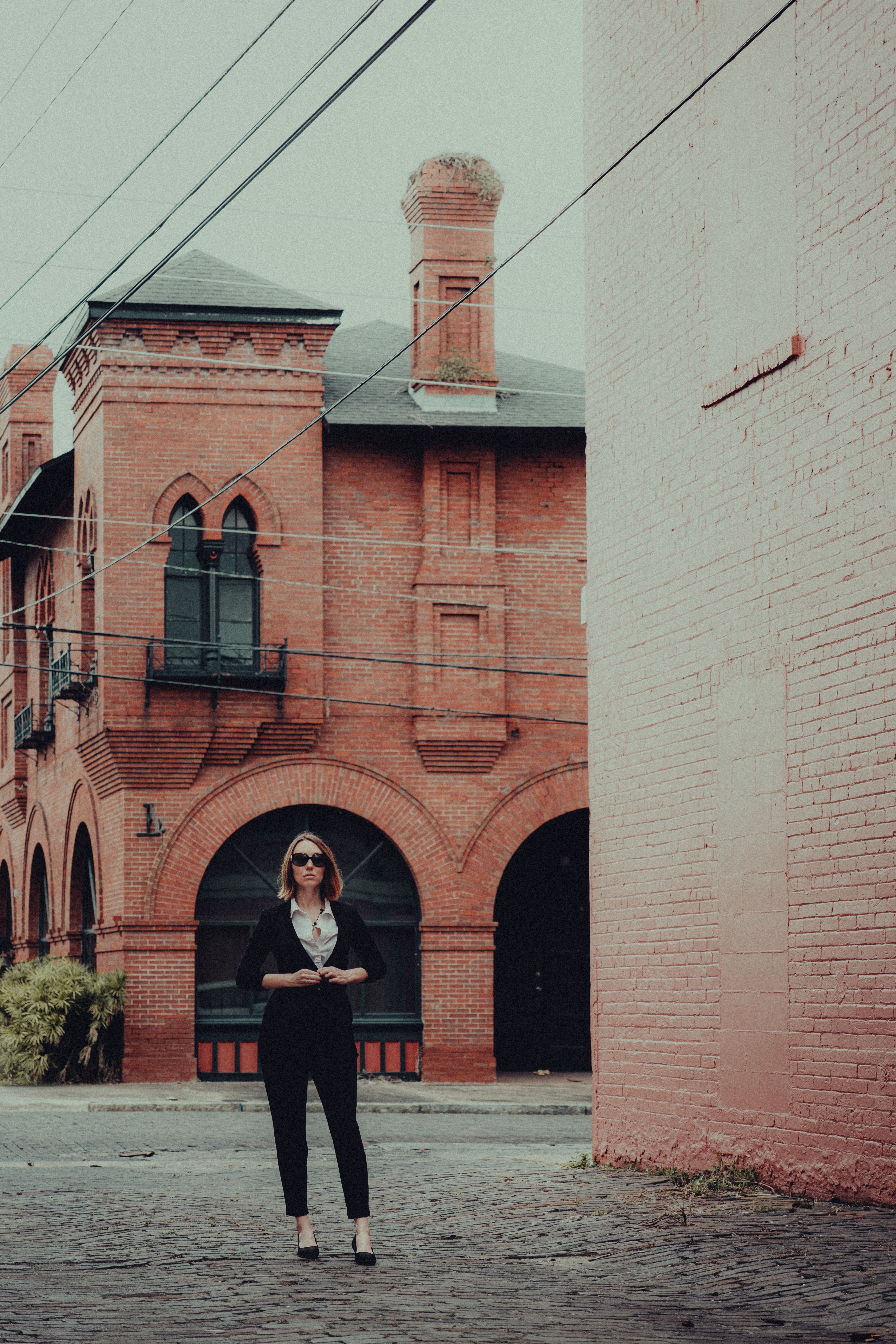 Woman in Black Suit Standing on Paving Street · Free Stock Photo