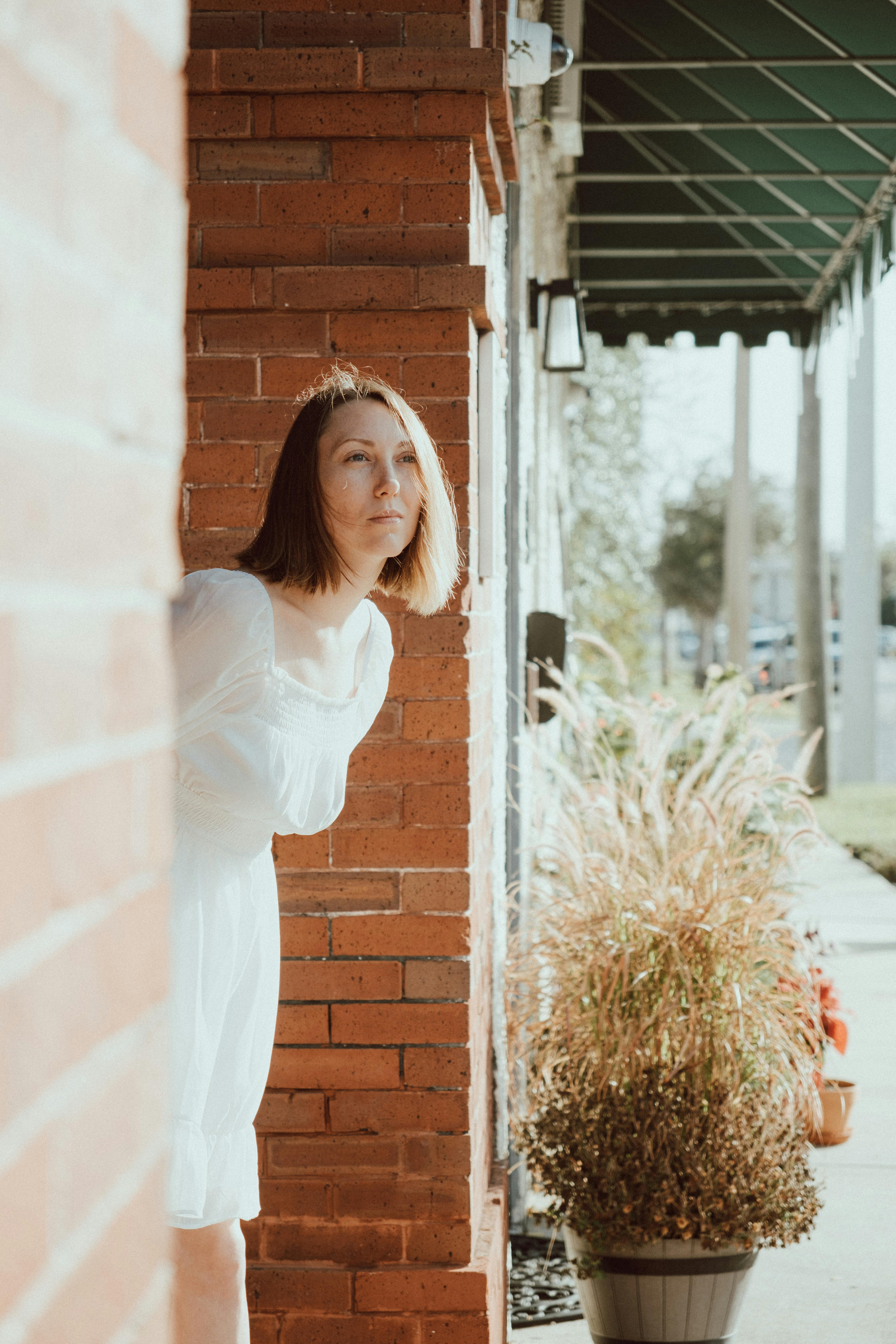 Woman Lurking from behind Wall · Free Stock Photo