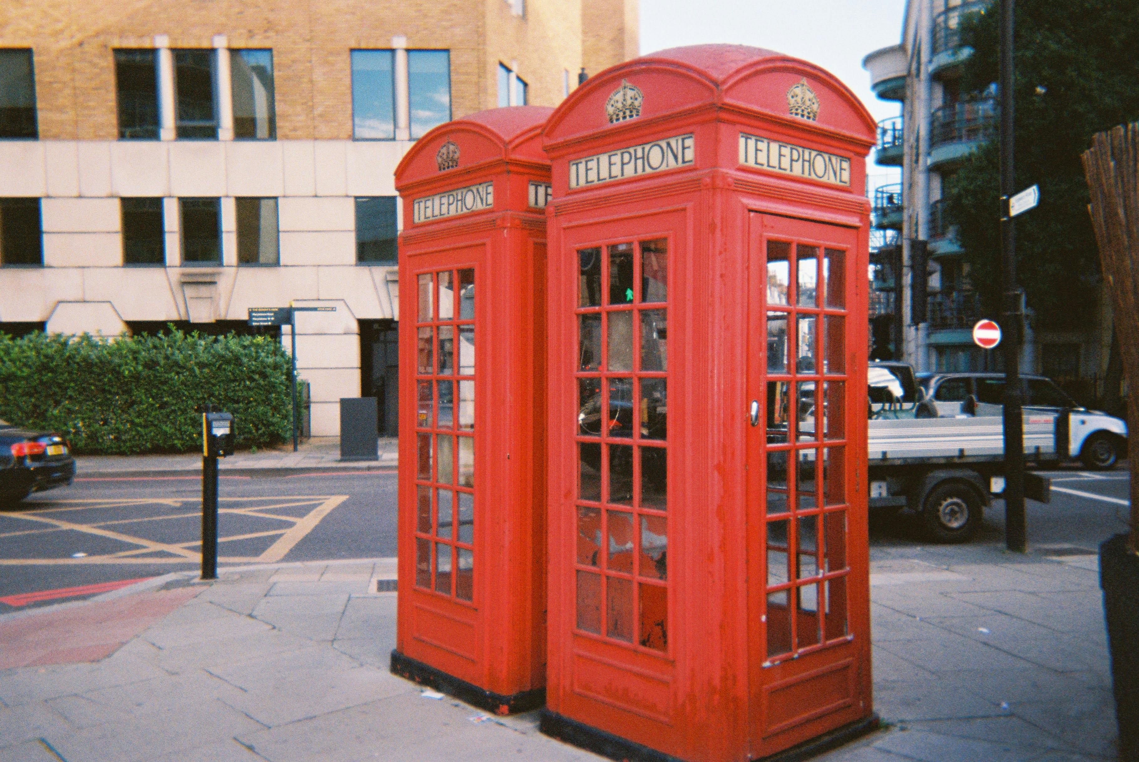 Red Telephone Booth Near White Building · Free Stock Photo