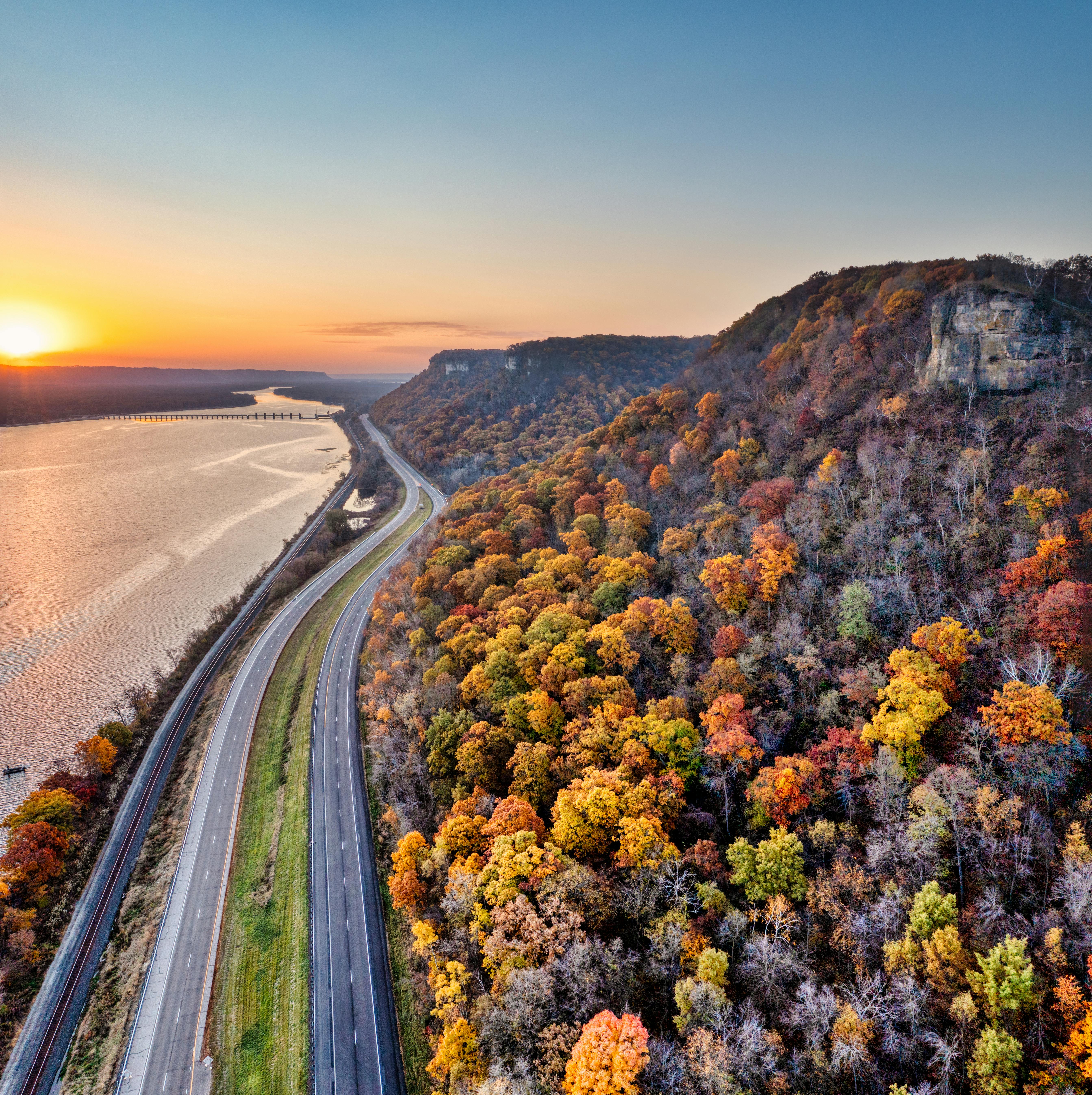 Aerial View of a Mountain Covered in Colorful Trees and a River at ...