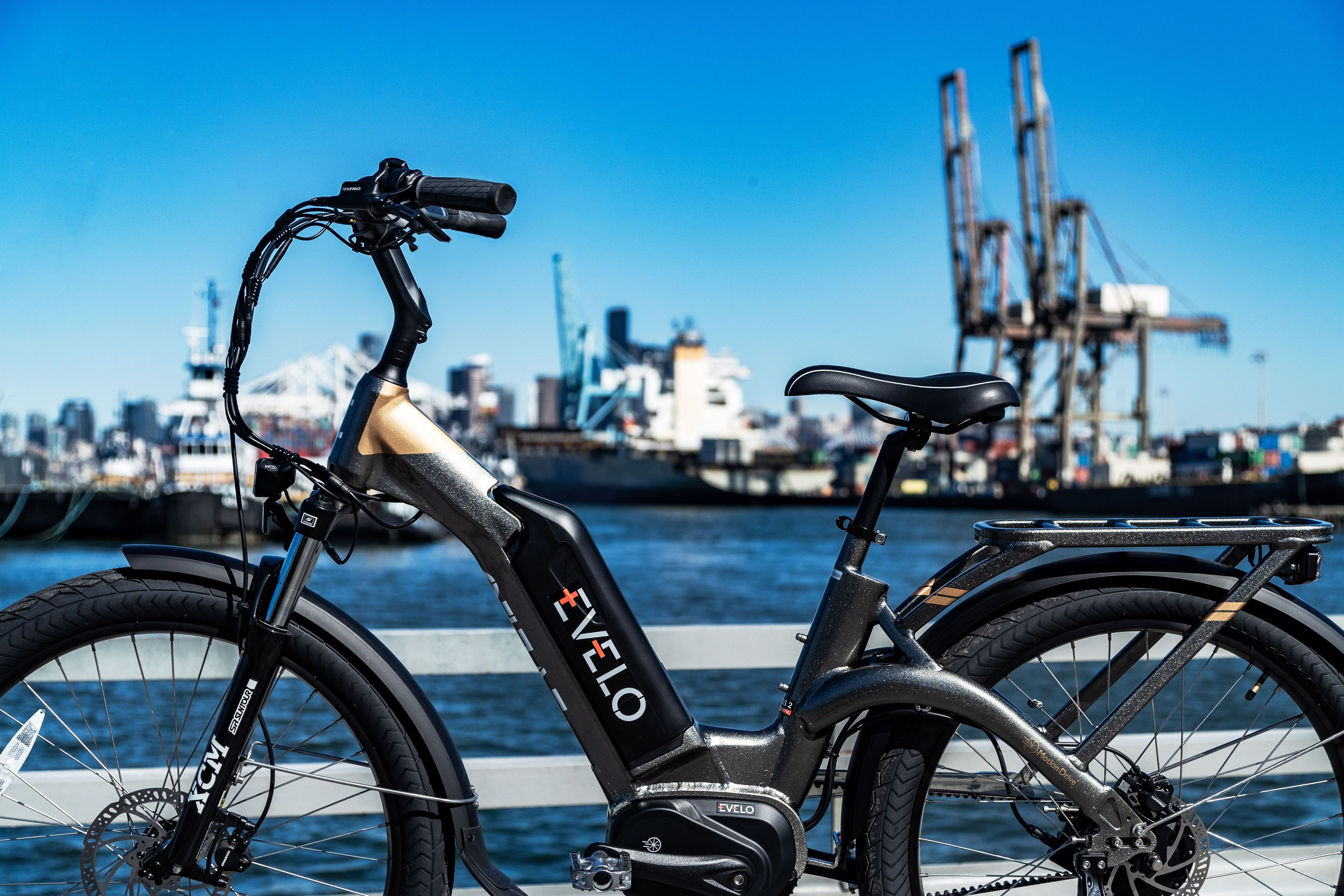 A black electric bike parked on the dock by the water · Free Stock Photo