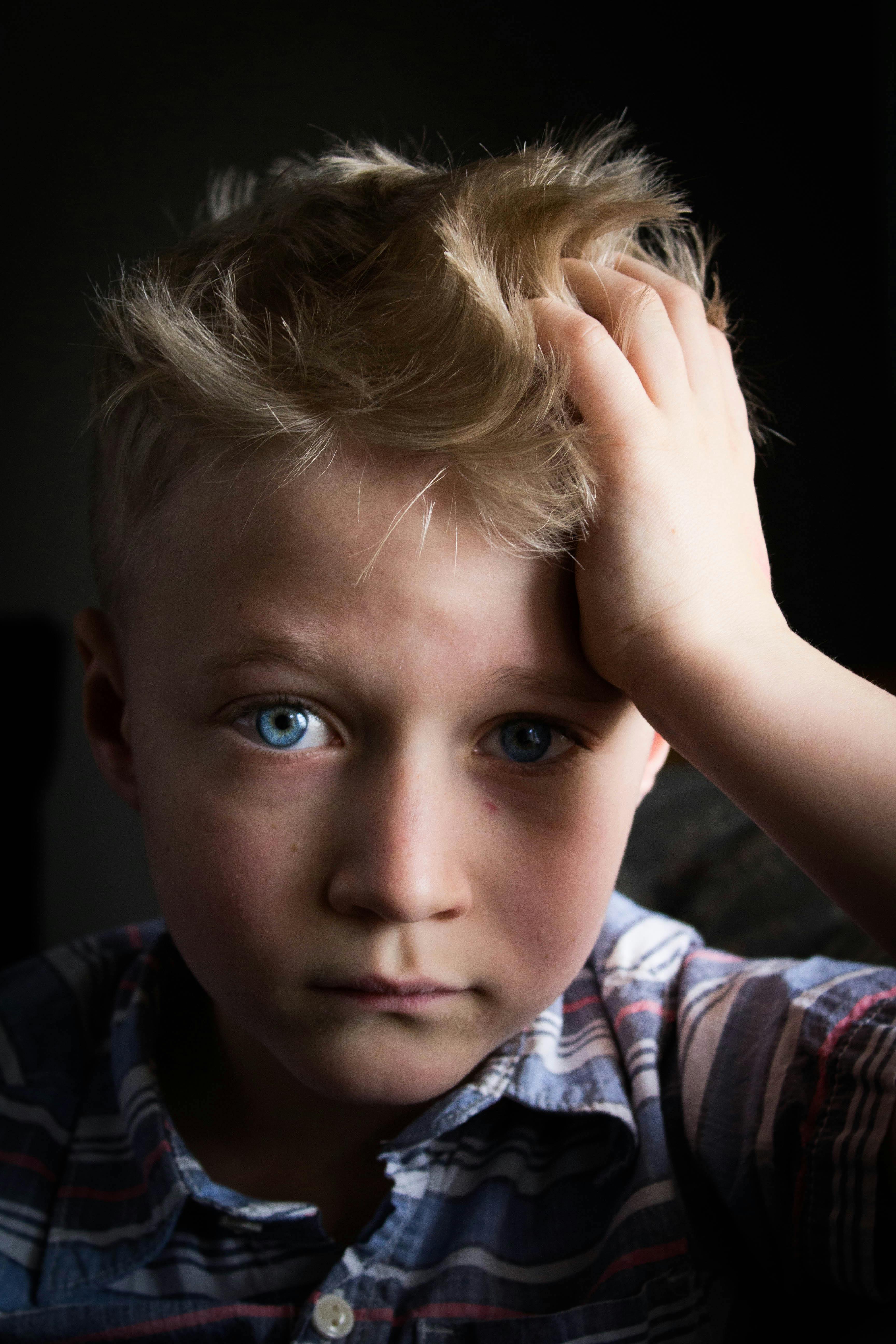 Close Up Photo of Boy with His Hand on His Head · Free Stock Photo