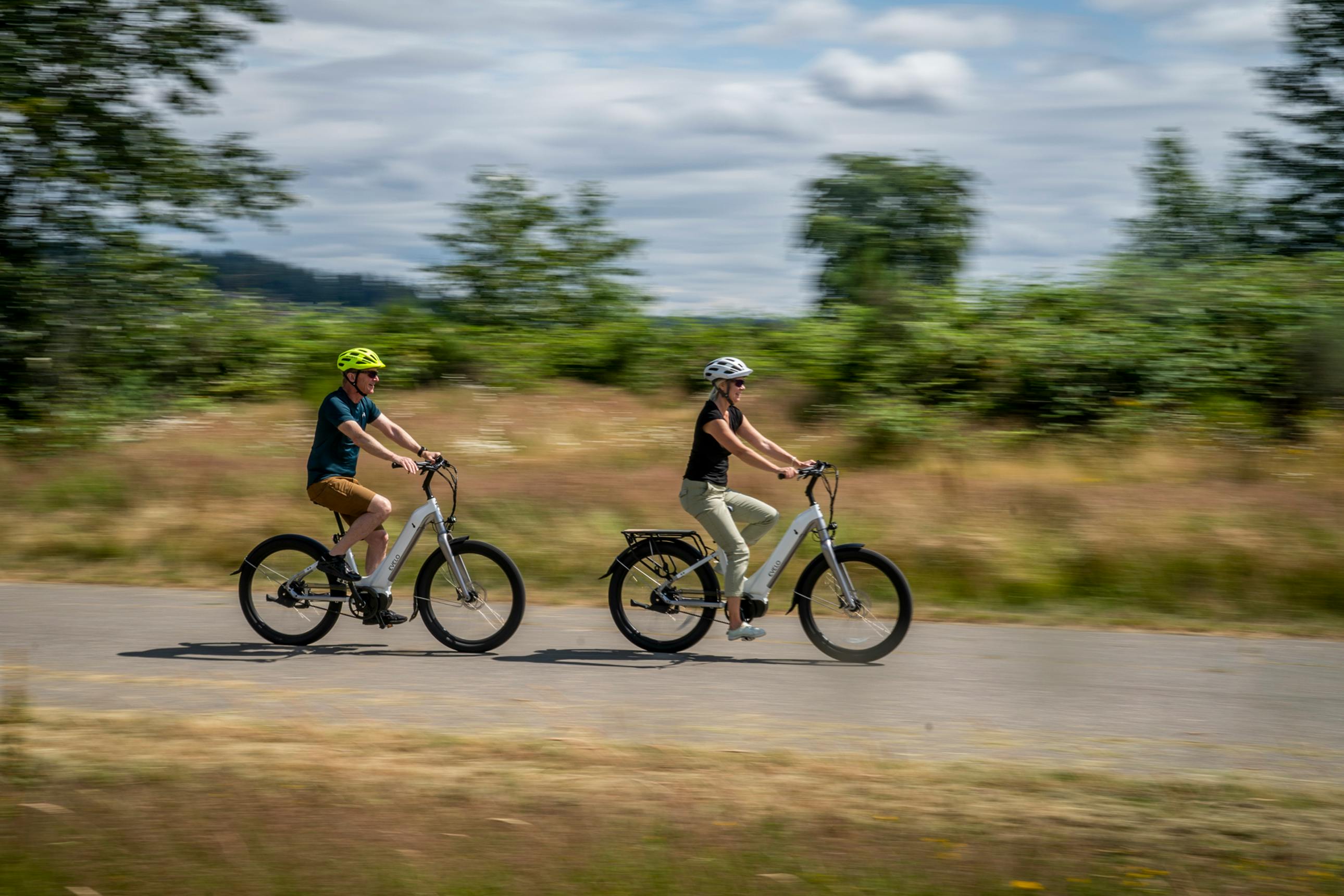A Couple Bicycling Fast on a Rural Road · Free Stock Photo