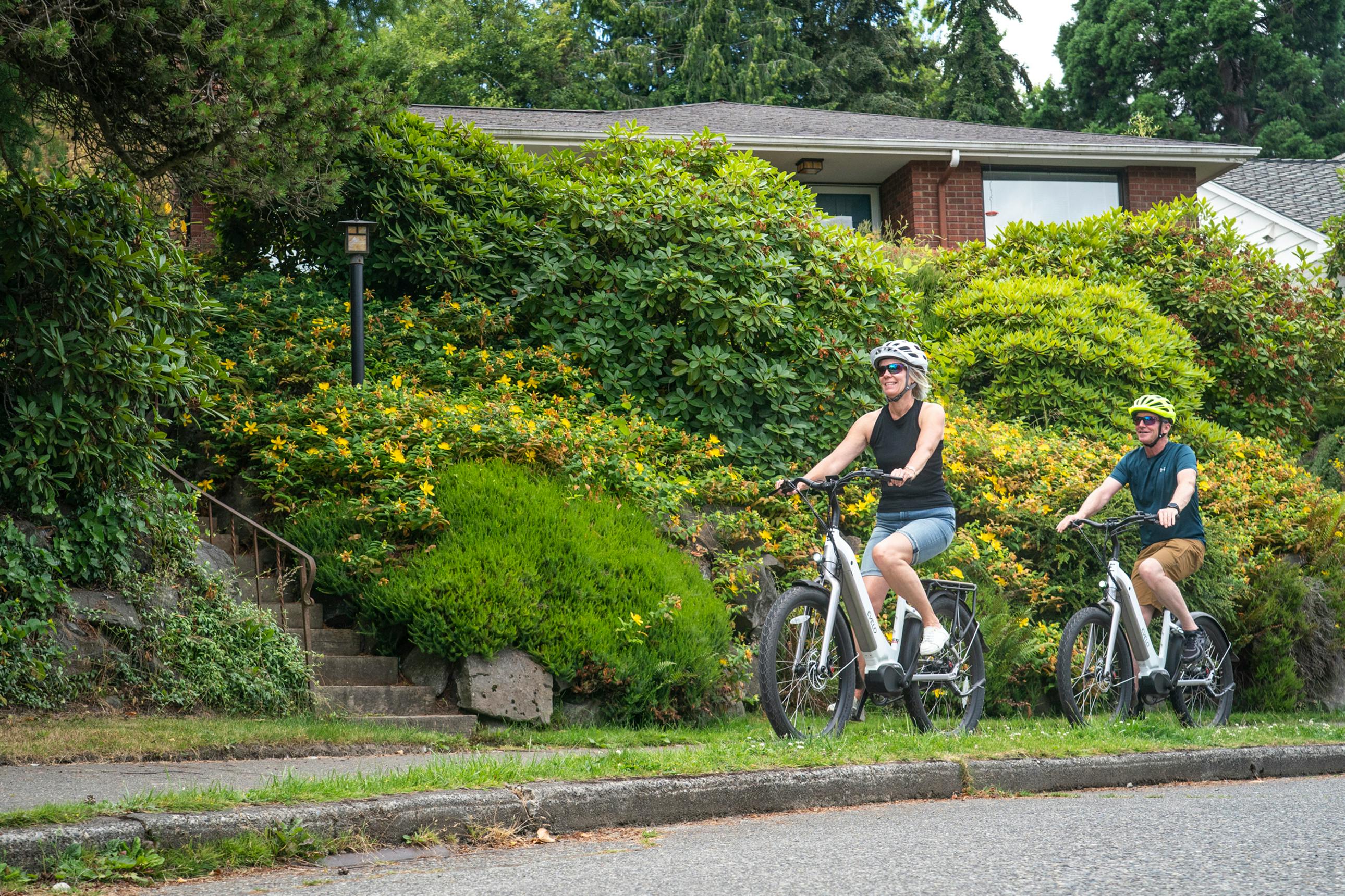 A Couple Wearing Helmets Riding Electric Bikes on Sidewalk · Free Stock ...