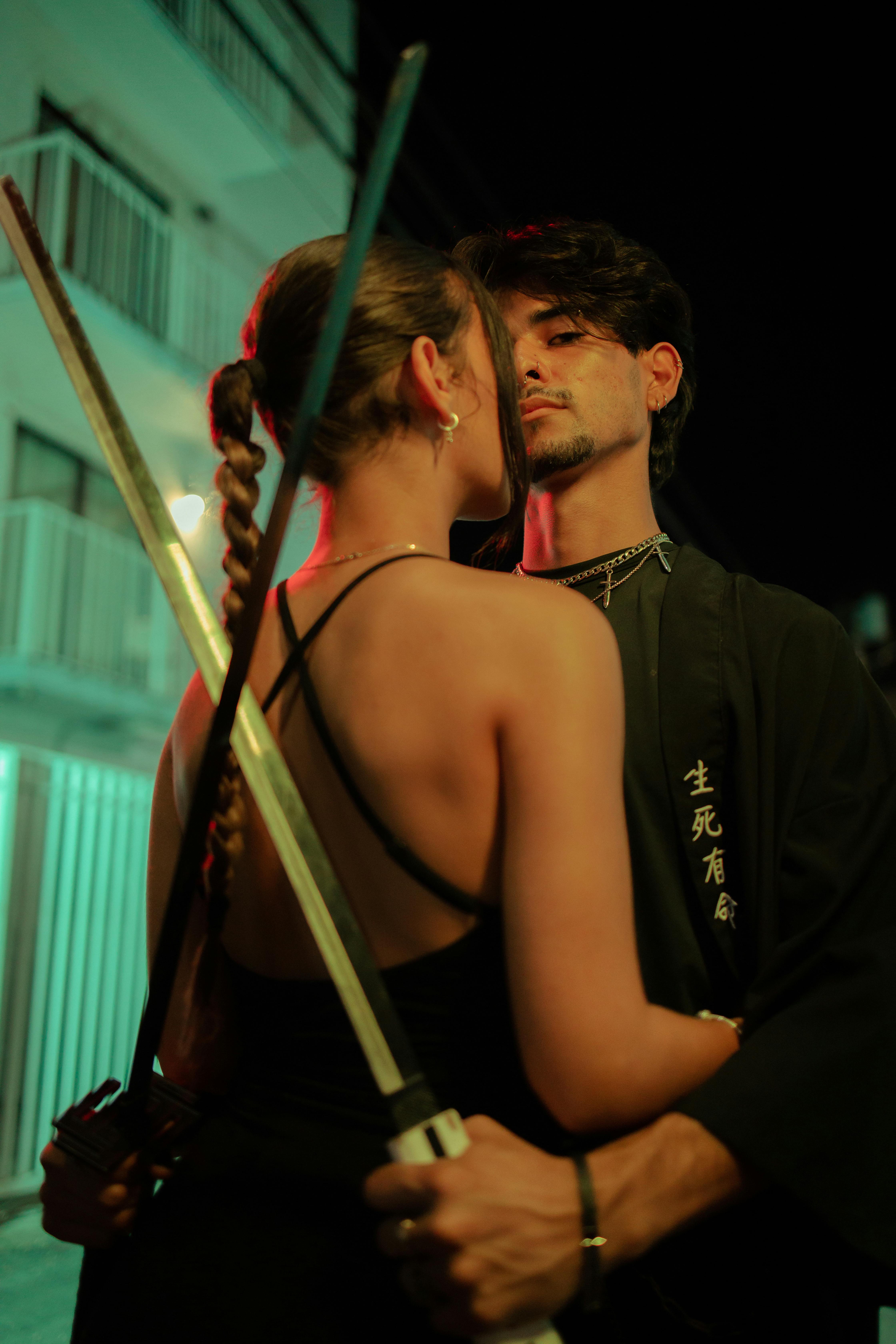 Man with Swords in his Hands Embracing a Woman · Free Stock Photo