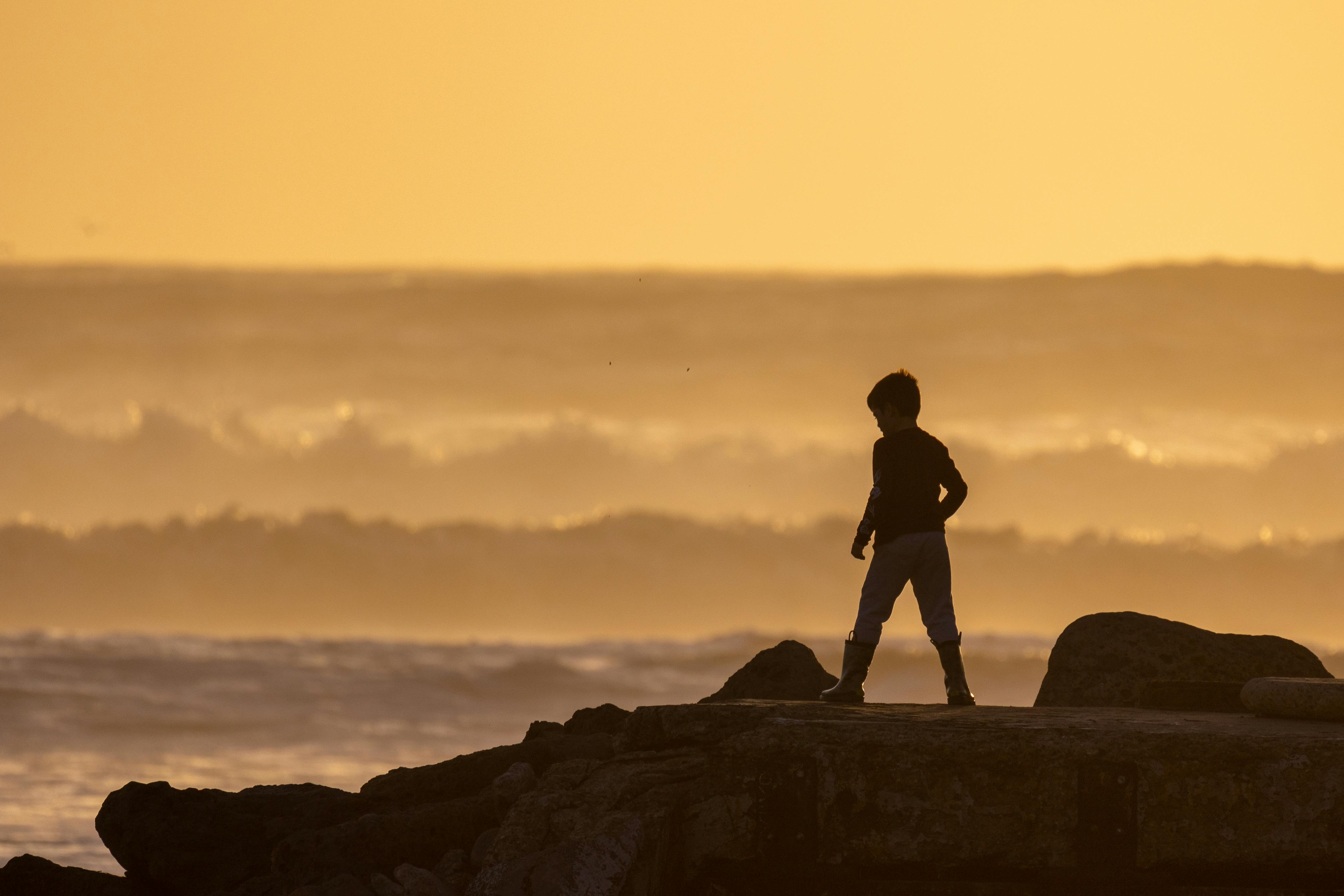 Boy on Sea Shore at Sunset · Free Stock Photo