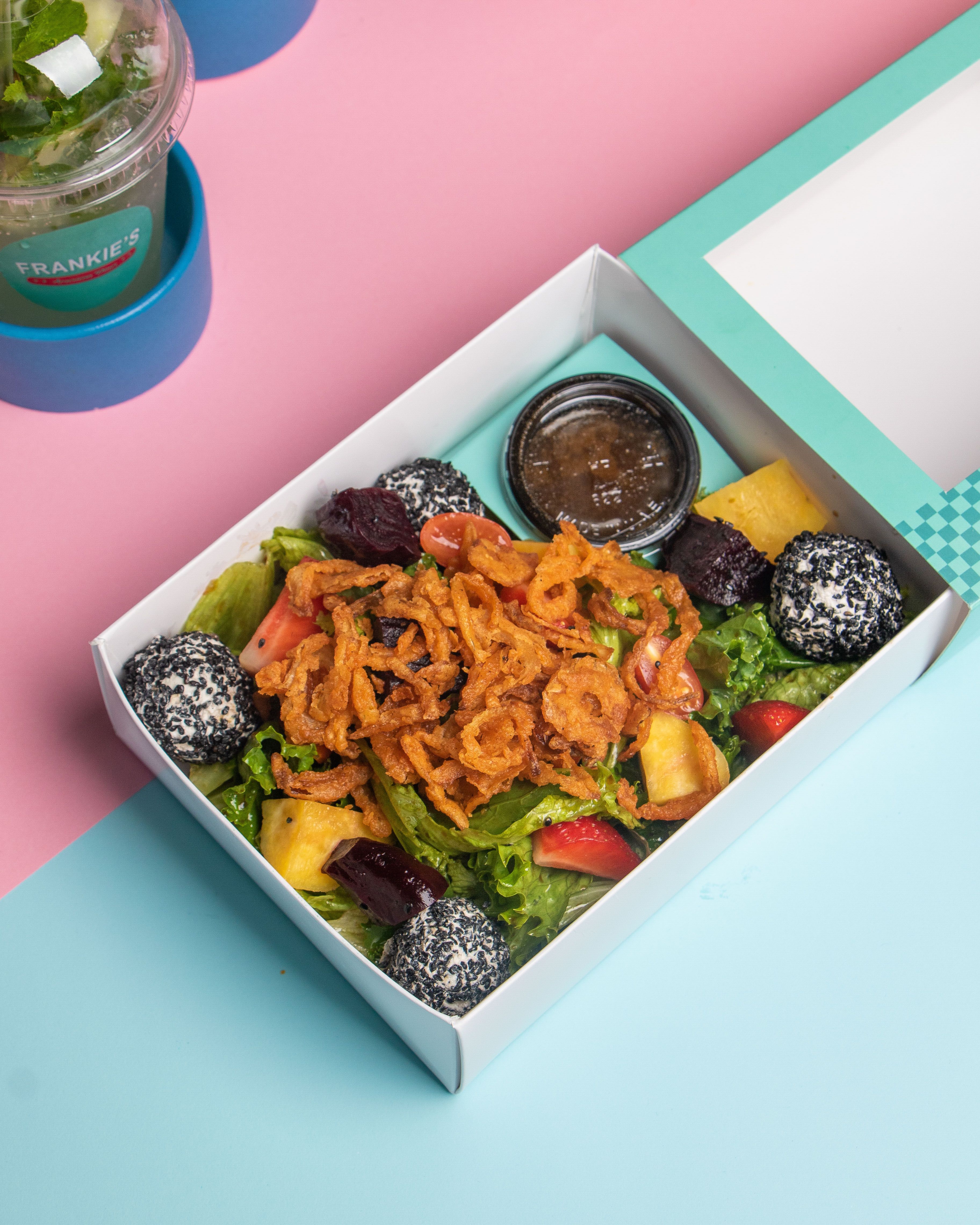 A salad box with fruit and a drink in it · Free Stock Photo