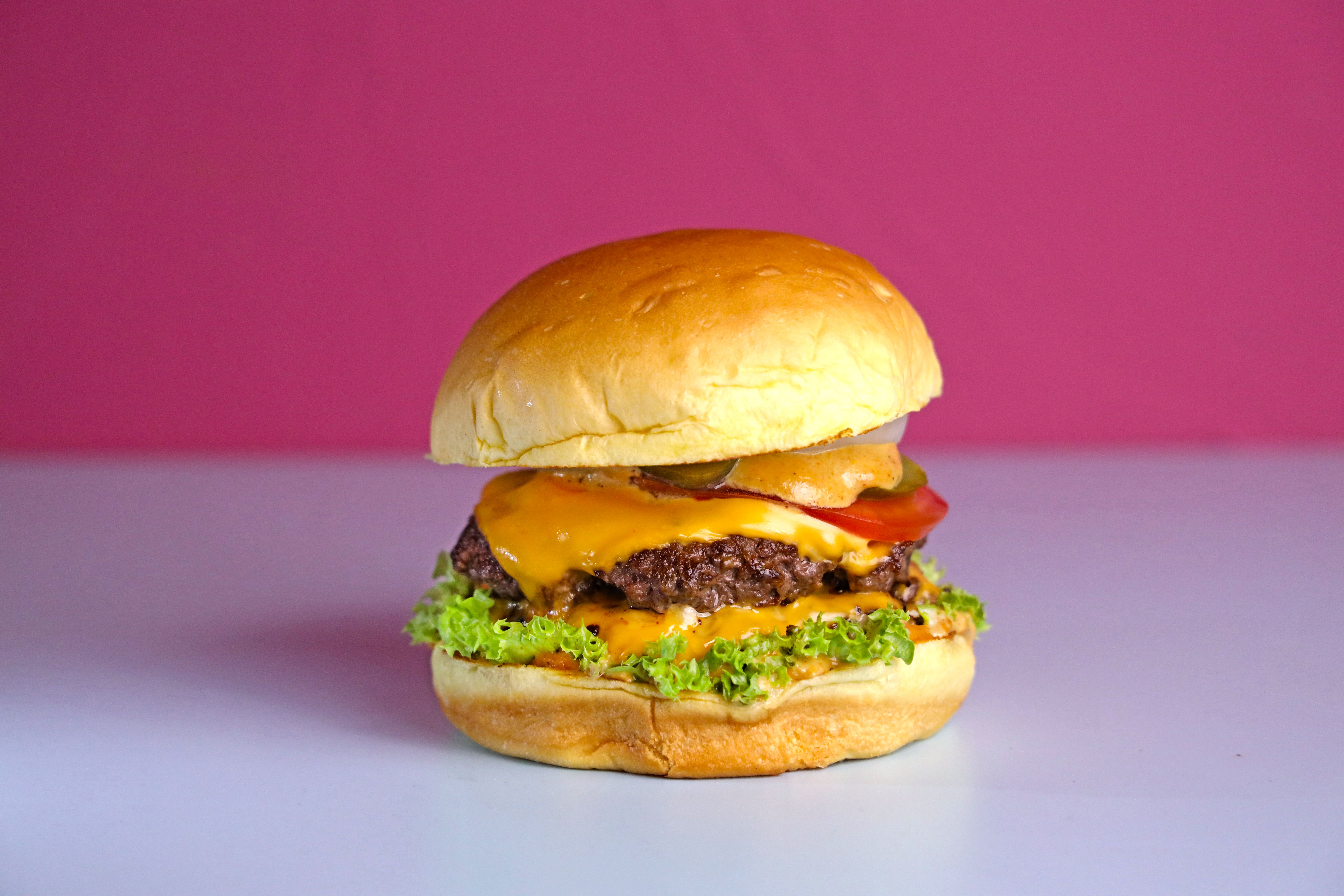 Close-Up Shot of a Delicious Hamburger on White Surface · Free Stock Photo