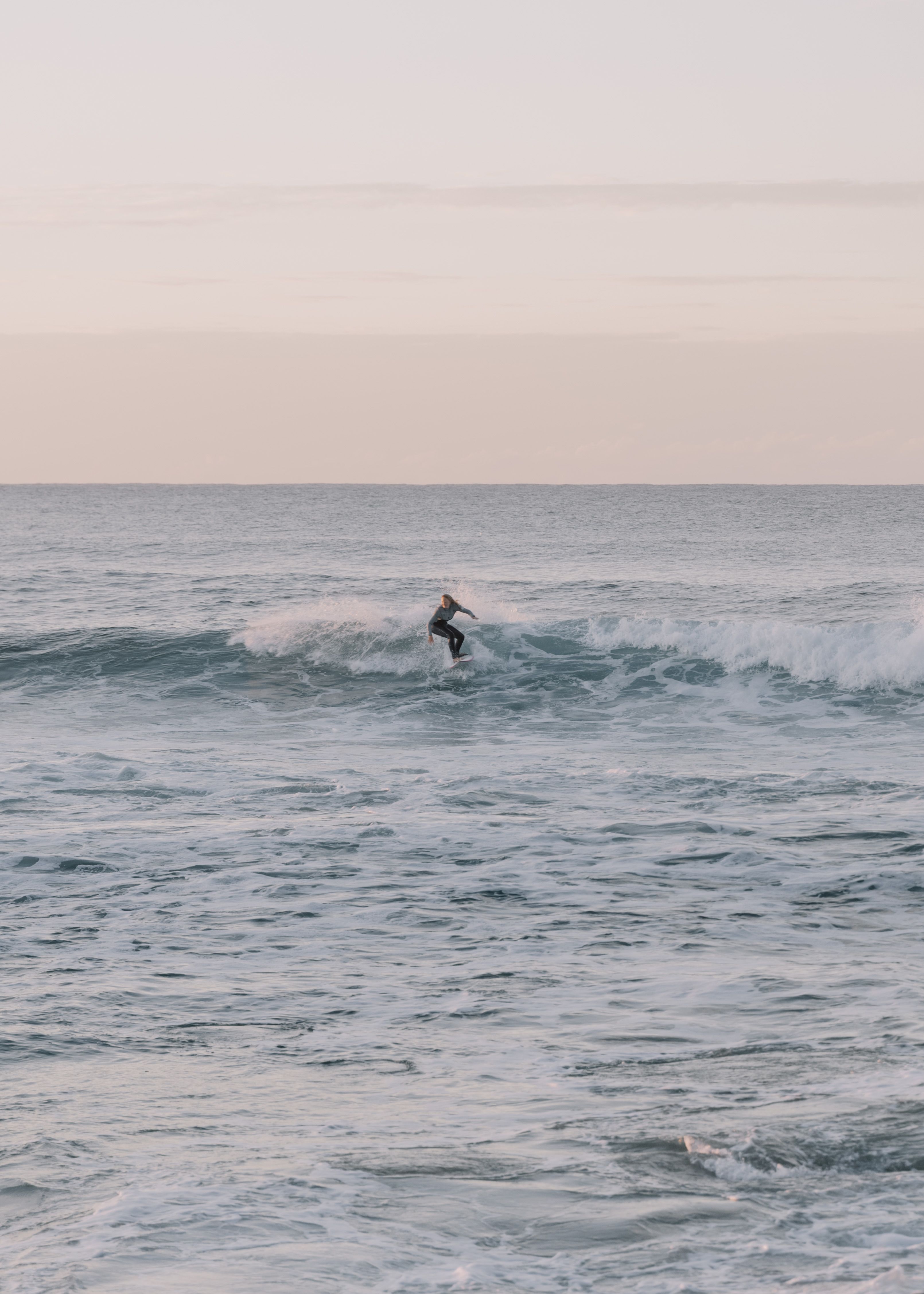 Serene Surfing at Dawn on Ocean Waves · Free Stock Photo