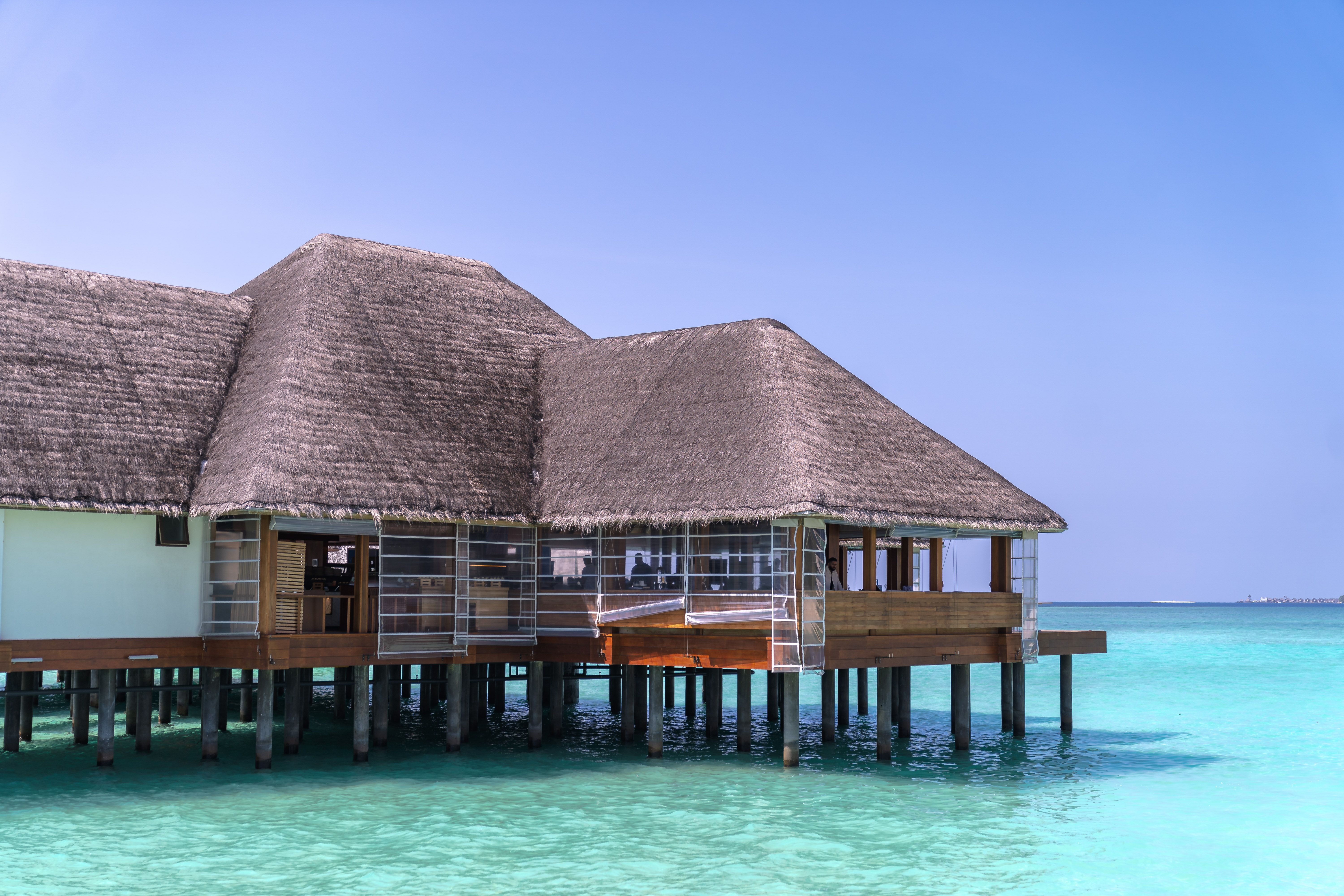 Architectural Photography of Brown Stilt Houses on Top of Sea Under ...