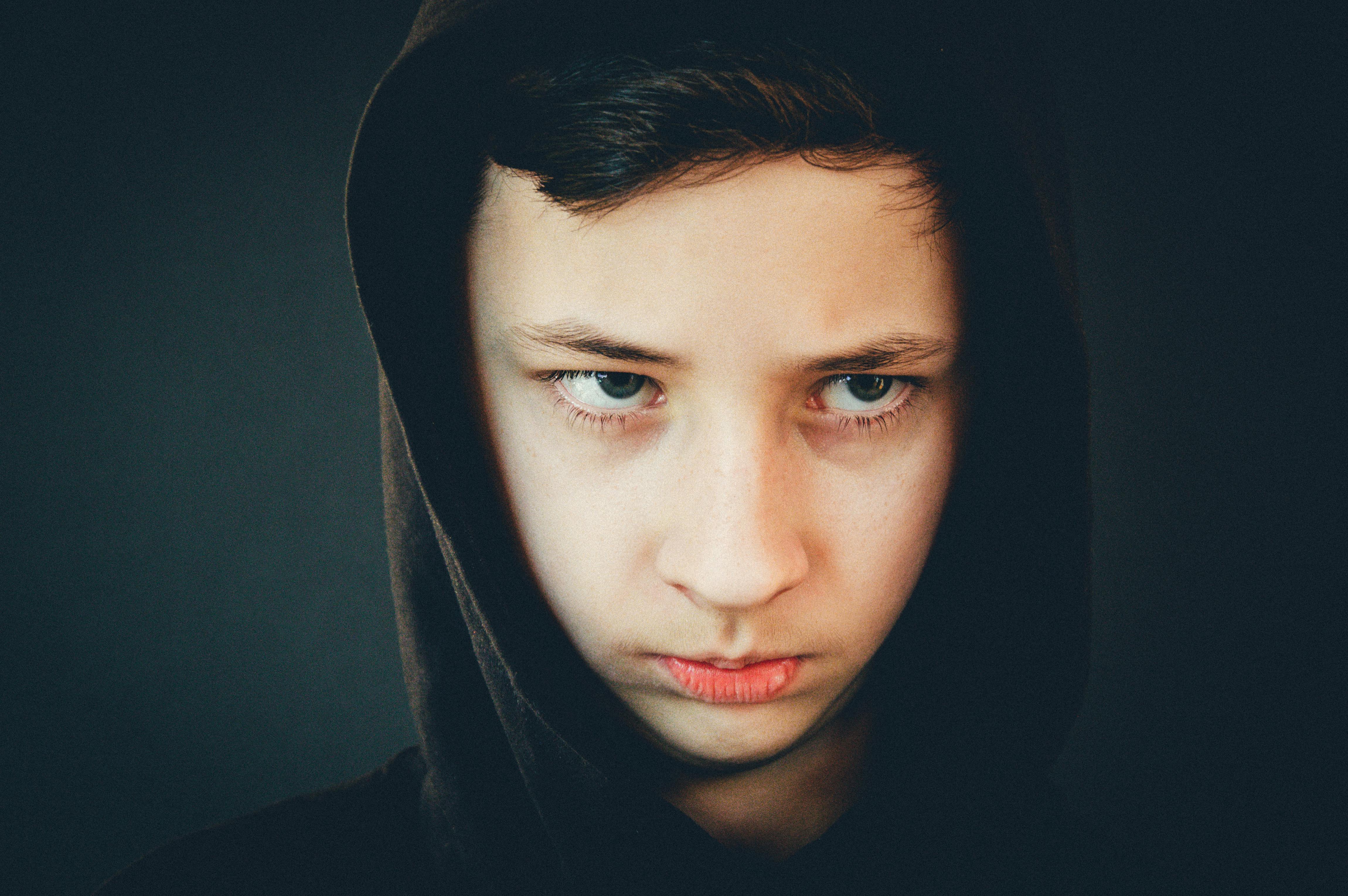 Angry Boy in Hood on Black Background · Free Stock Photo