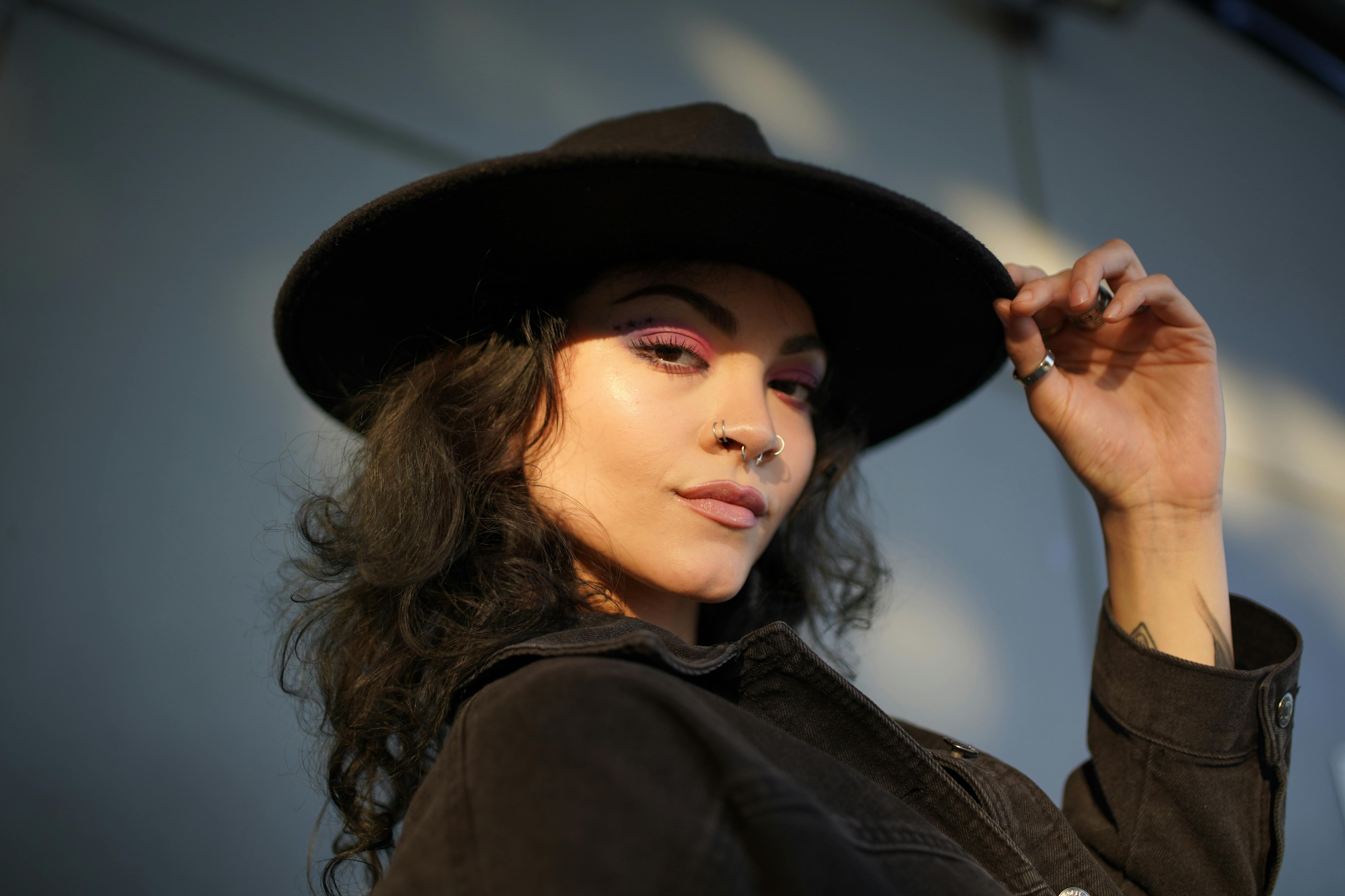 Serious female model in trendy cap in studio · Free Stock Photo