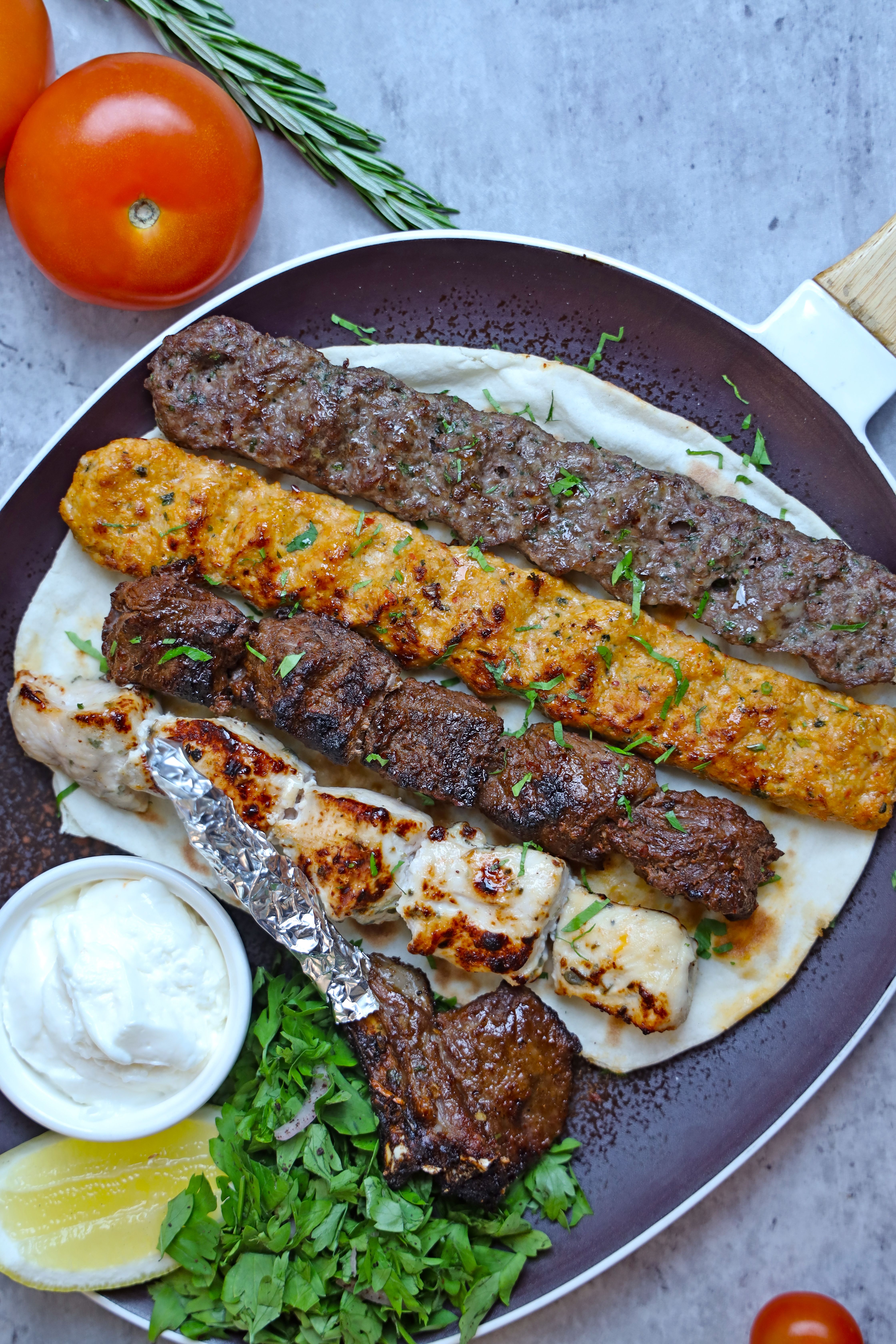 A plate of kebabs with vegetables and herbs · Free Stock Photo