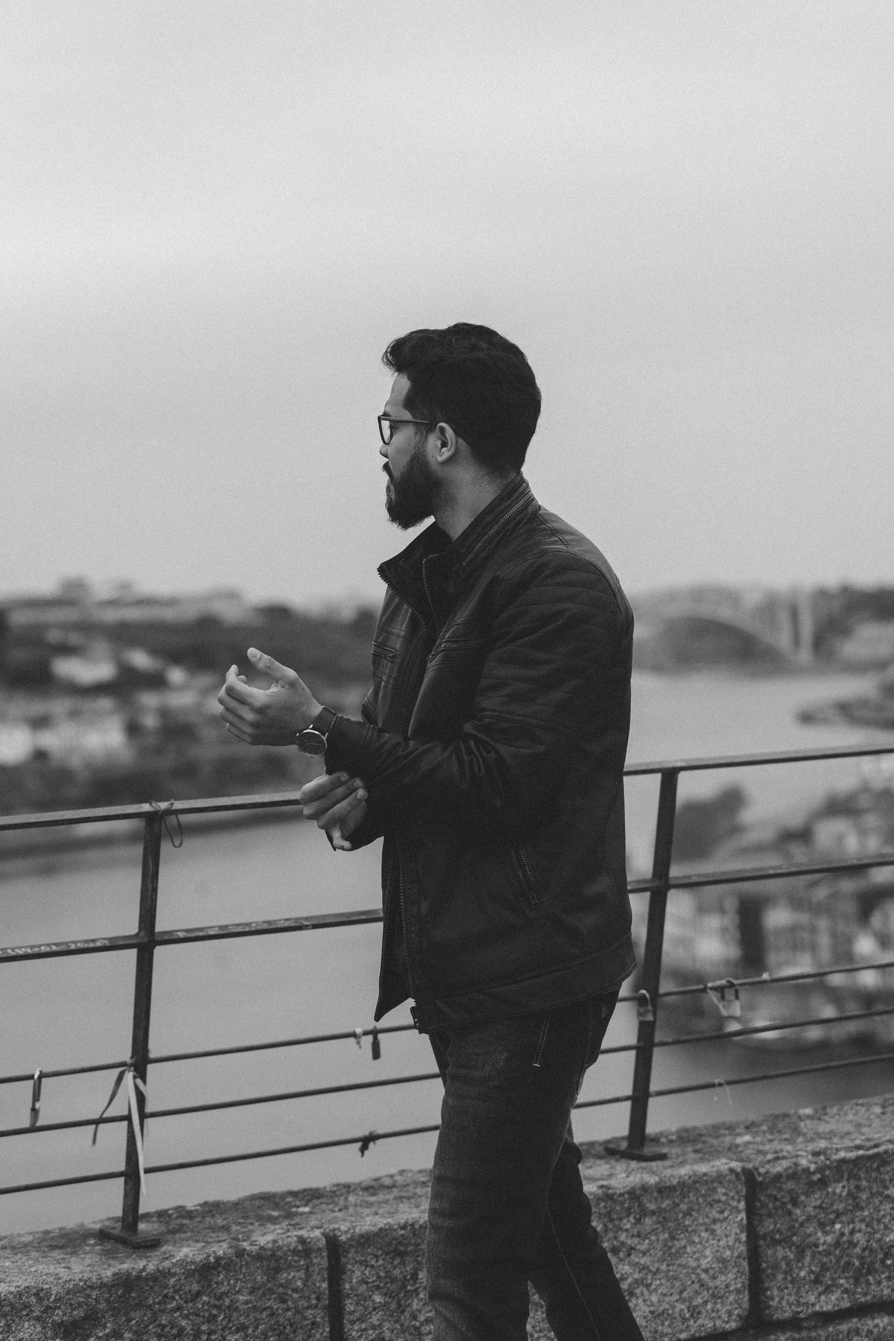 Grayscale Photo of Man Standing Beside the Railings · Free Stock Photo