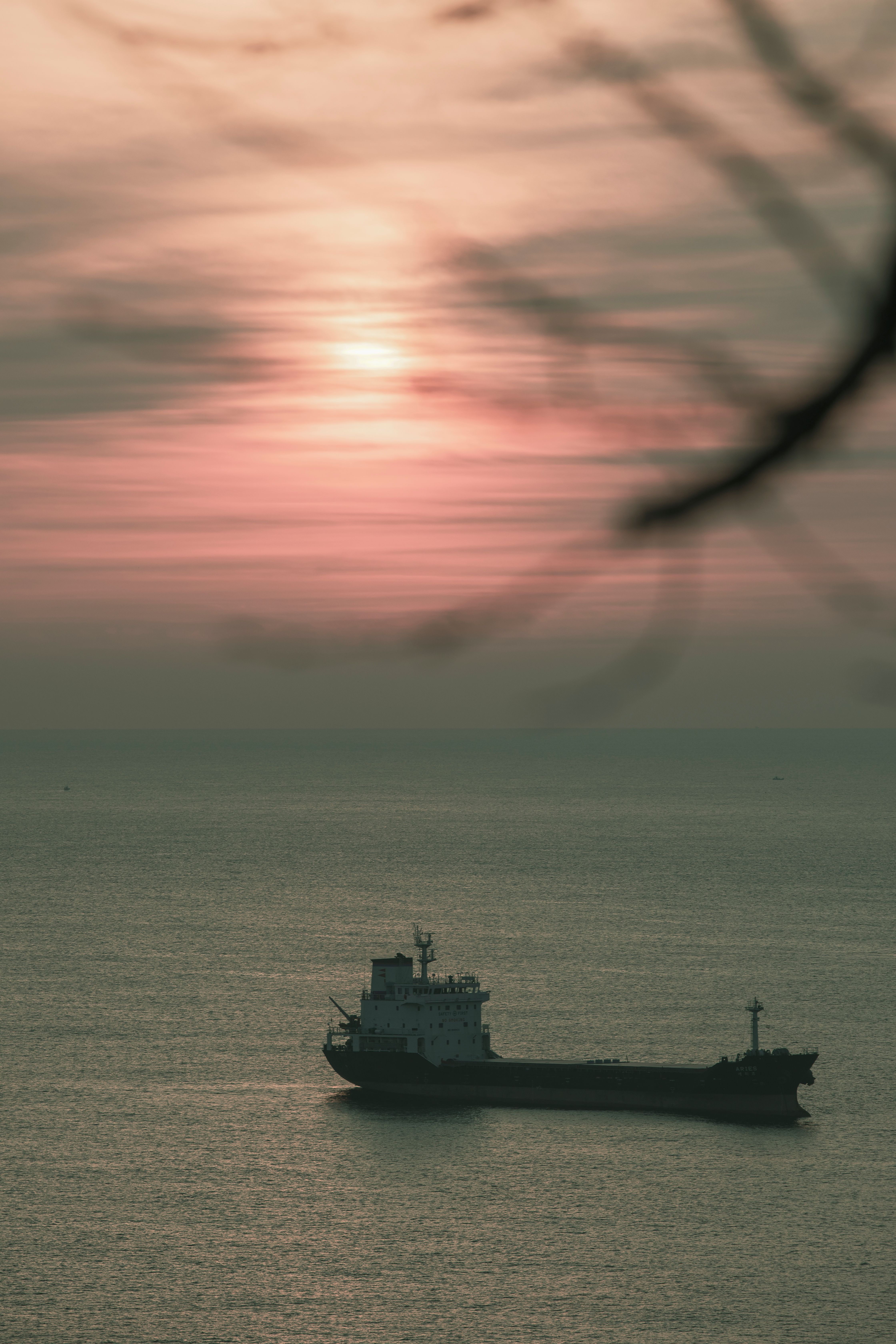 A Silhouetted Bulk Carrier on the Sea at Sunset · Free Stock Photo