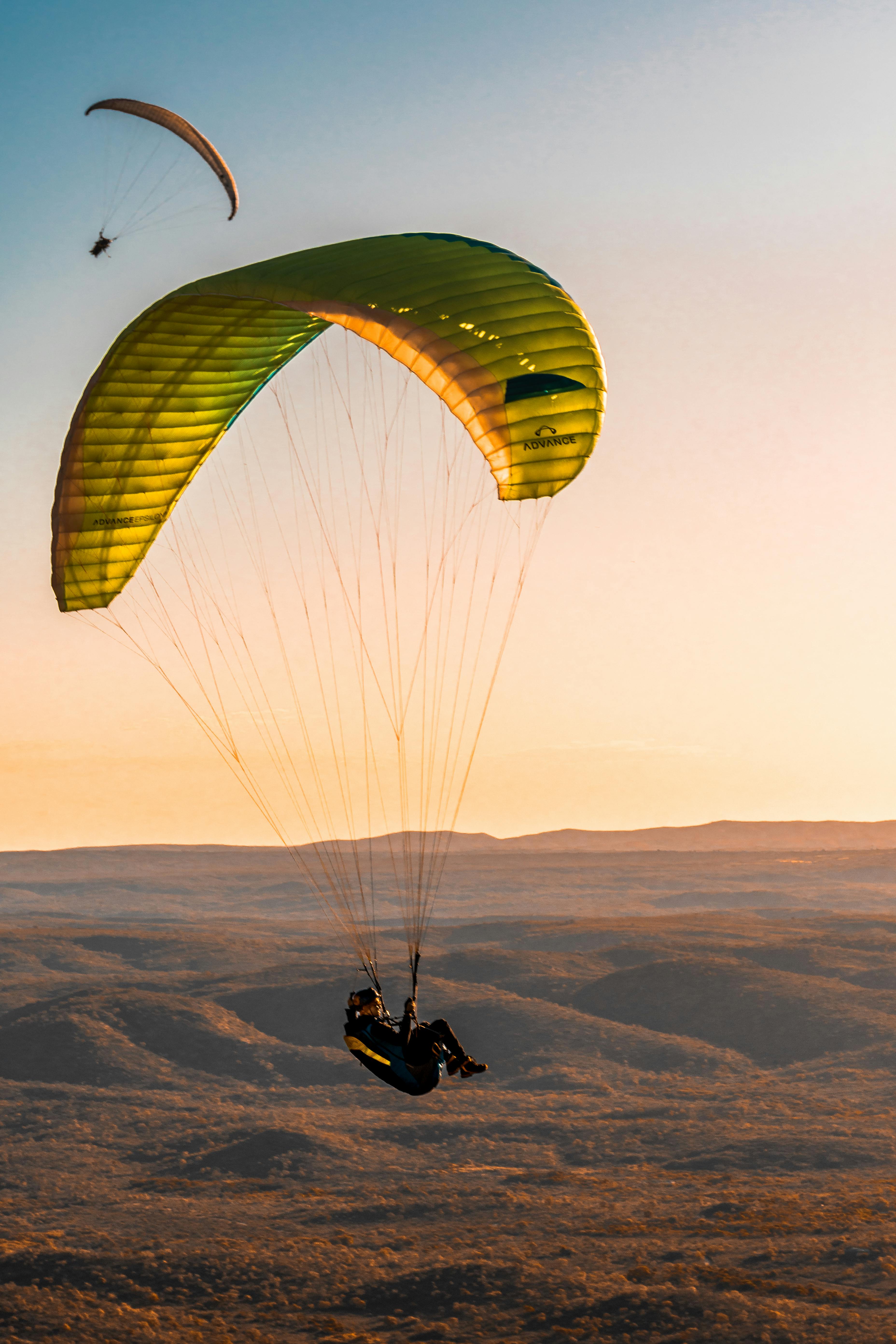 Person Flying on Parachute above Desert on Sunset · Free Stock Photo