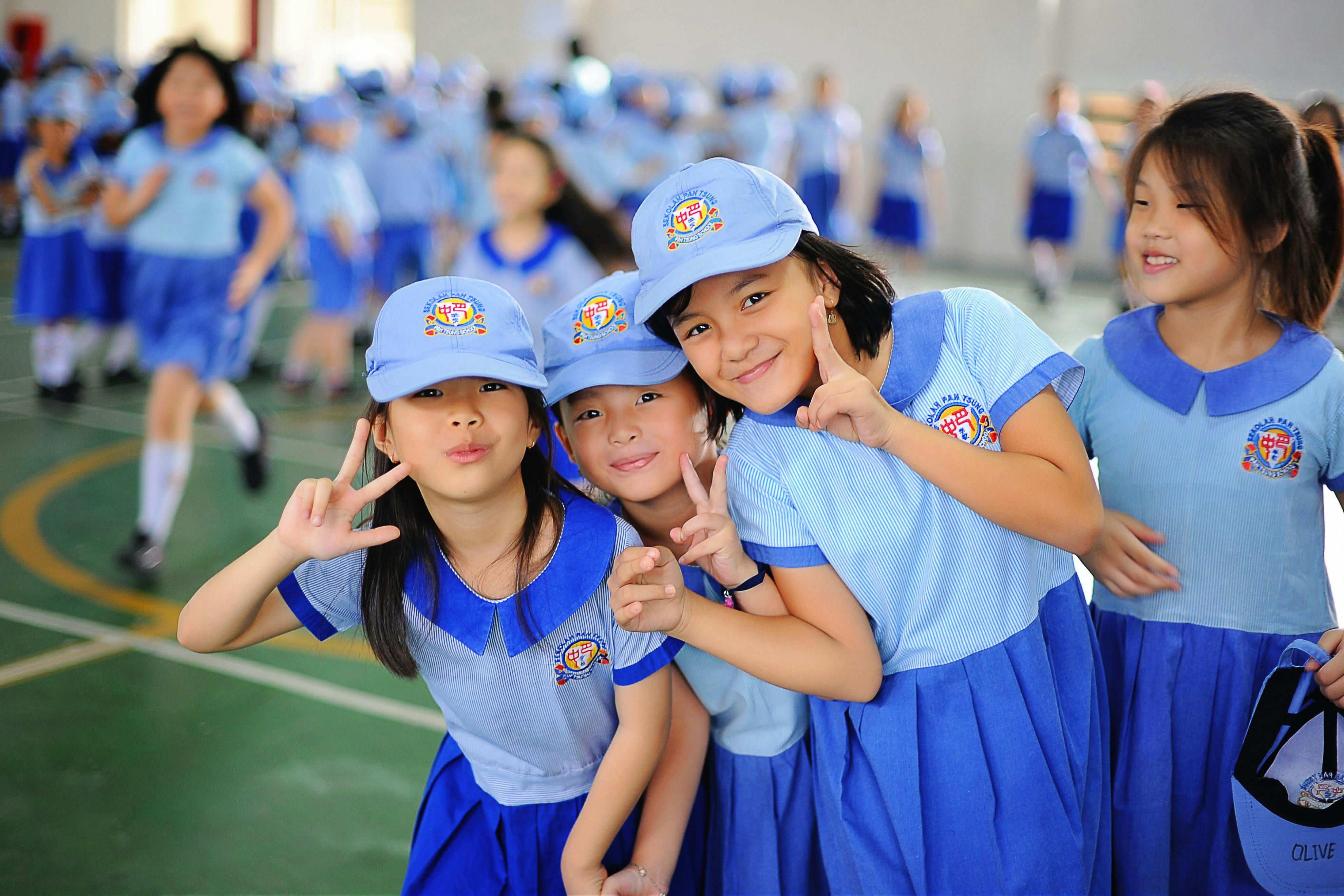 Schoolgirls in Uniforms Posing for a Photo in a Gym · Free Stock Photo