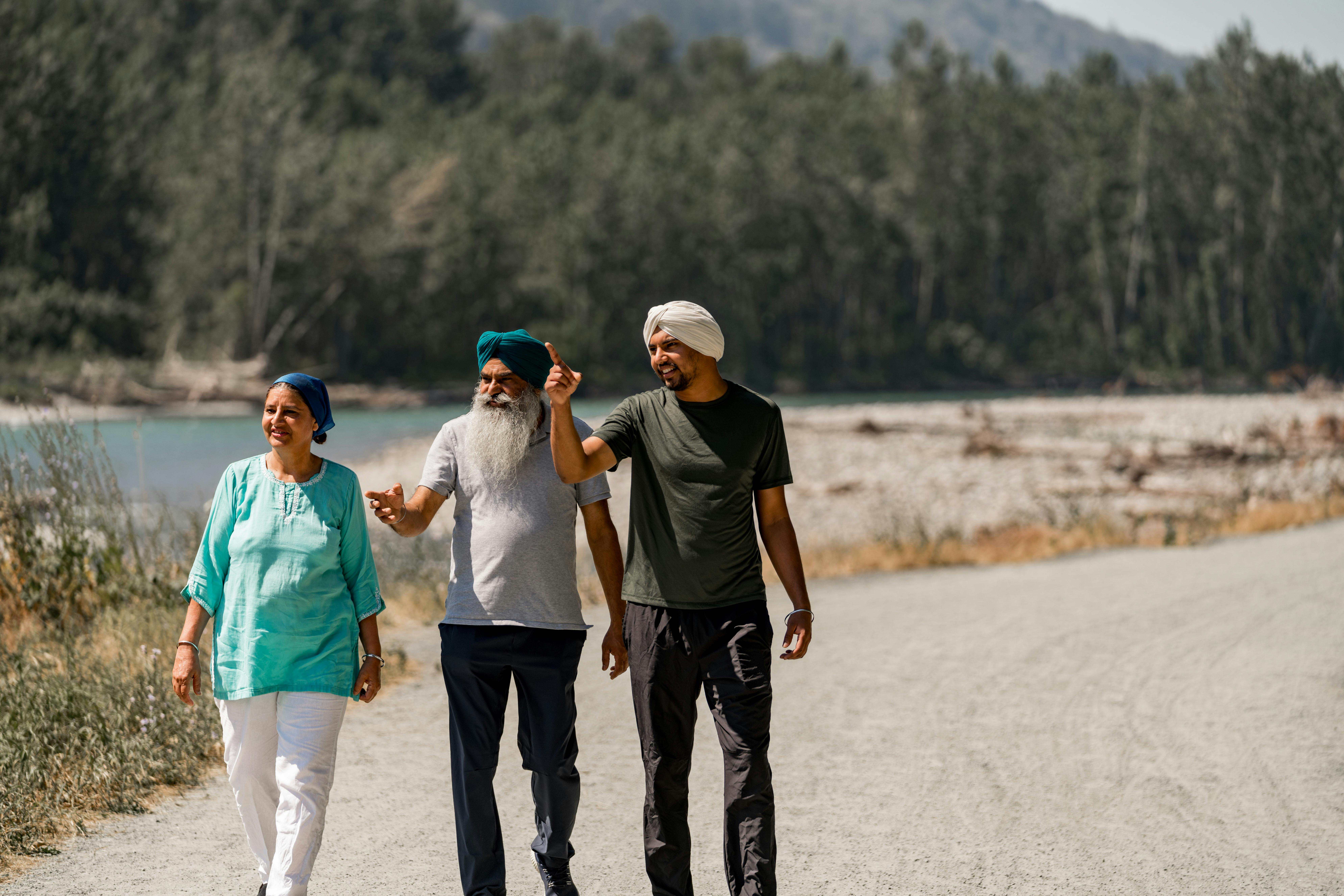 Three People Walking on Concrete Road · Free Stock Photo