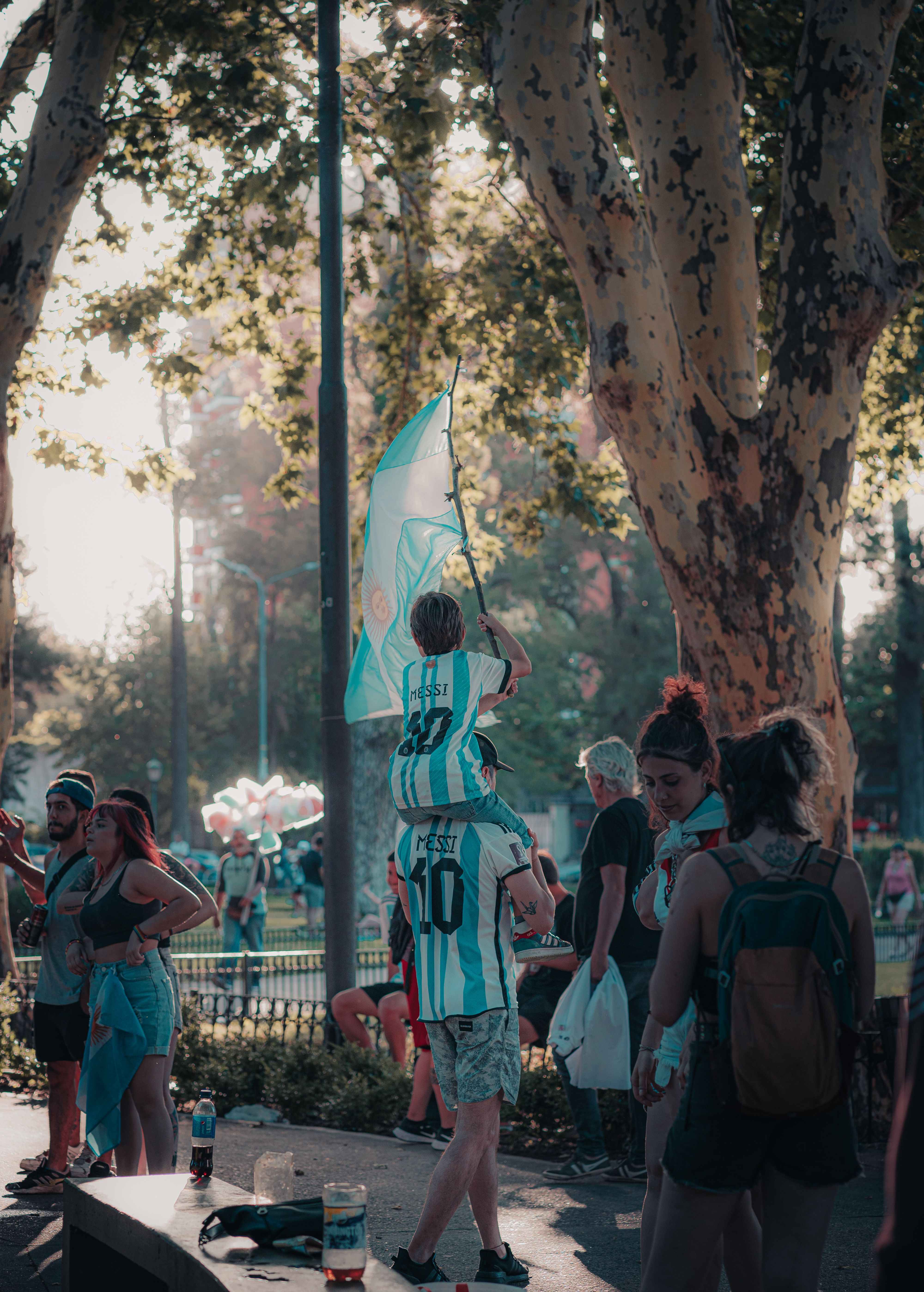 Man Carrying his Flag Waving Son on His Shoulders · Free Stock Photo