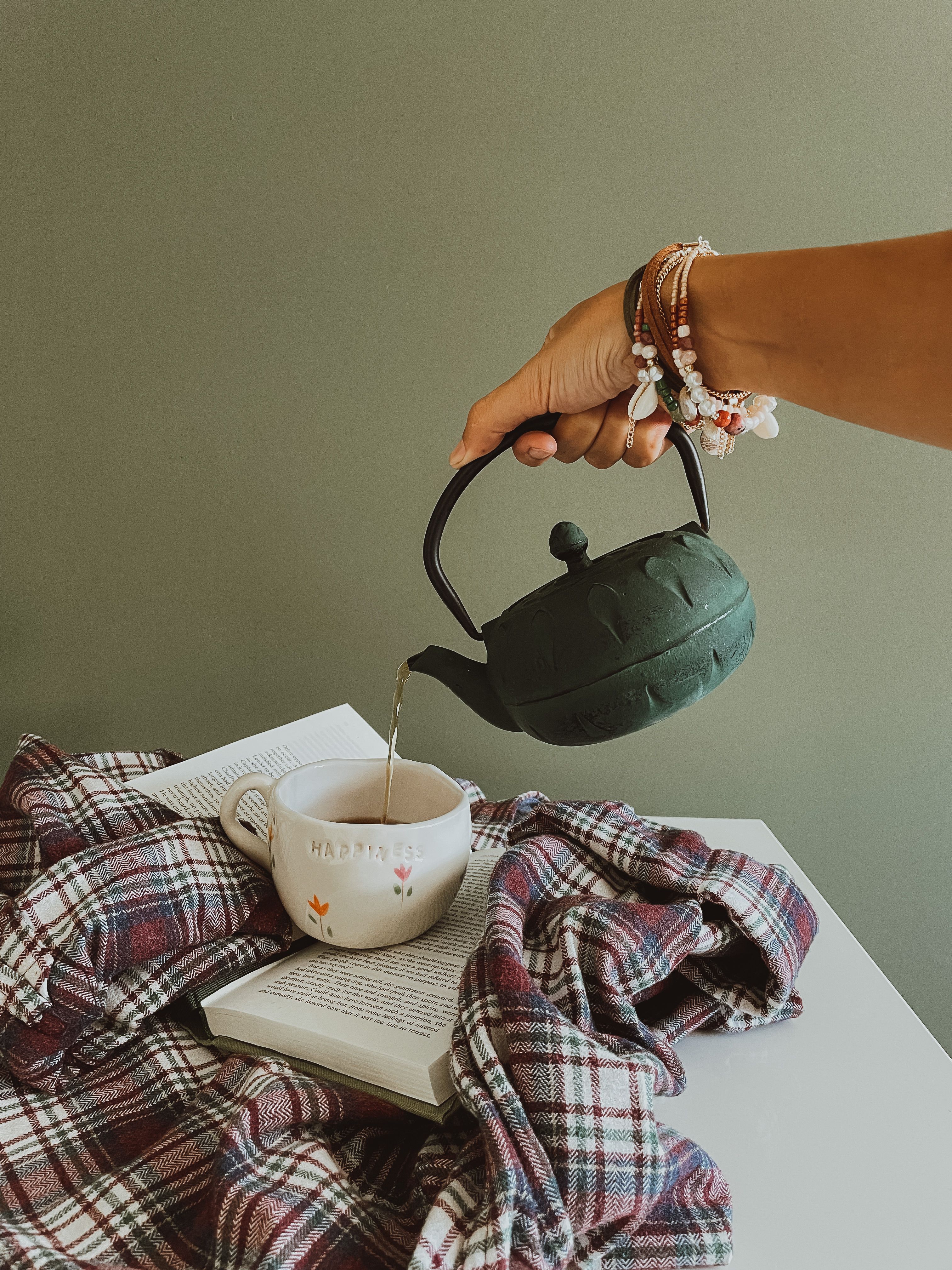 A person pouring tea into a teapot on a table · Free Stock Photo