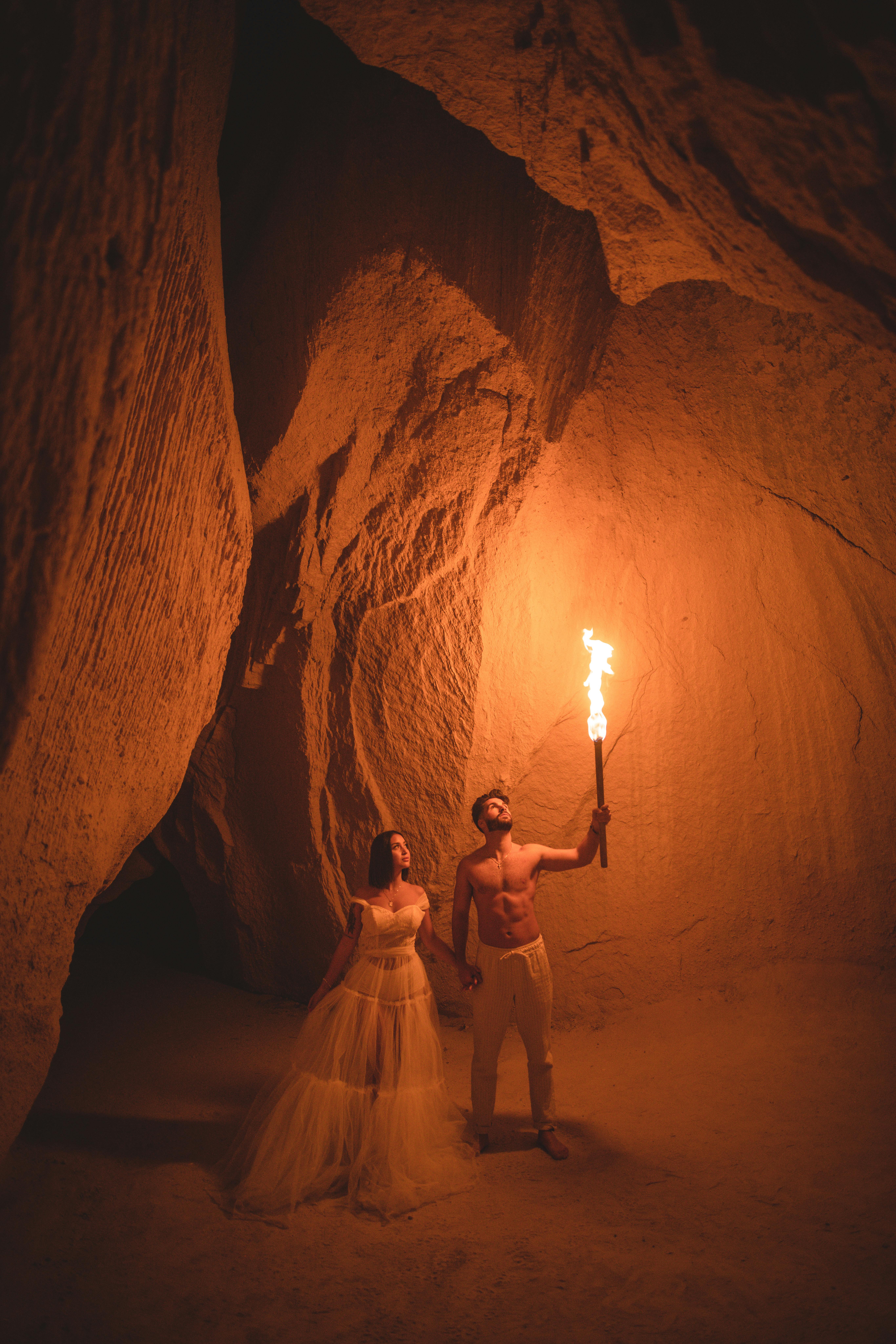 Woman and Man with Torch in Cave · Free Stock Photo