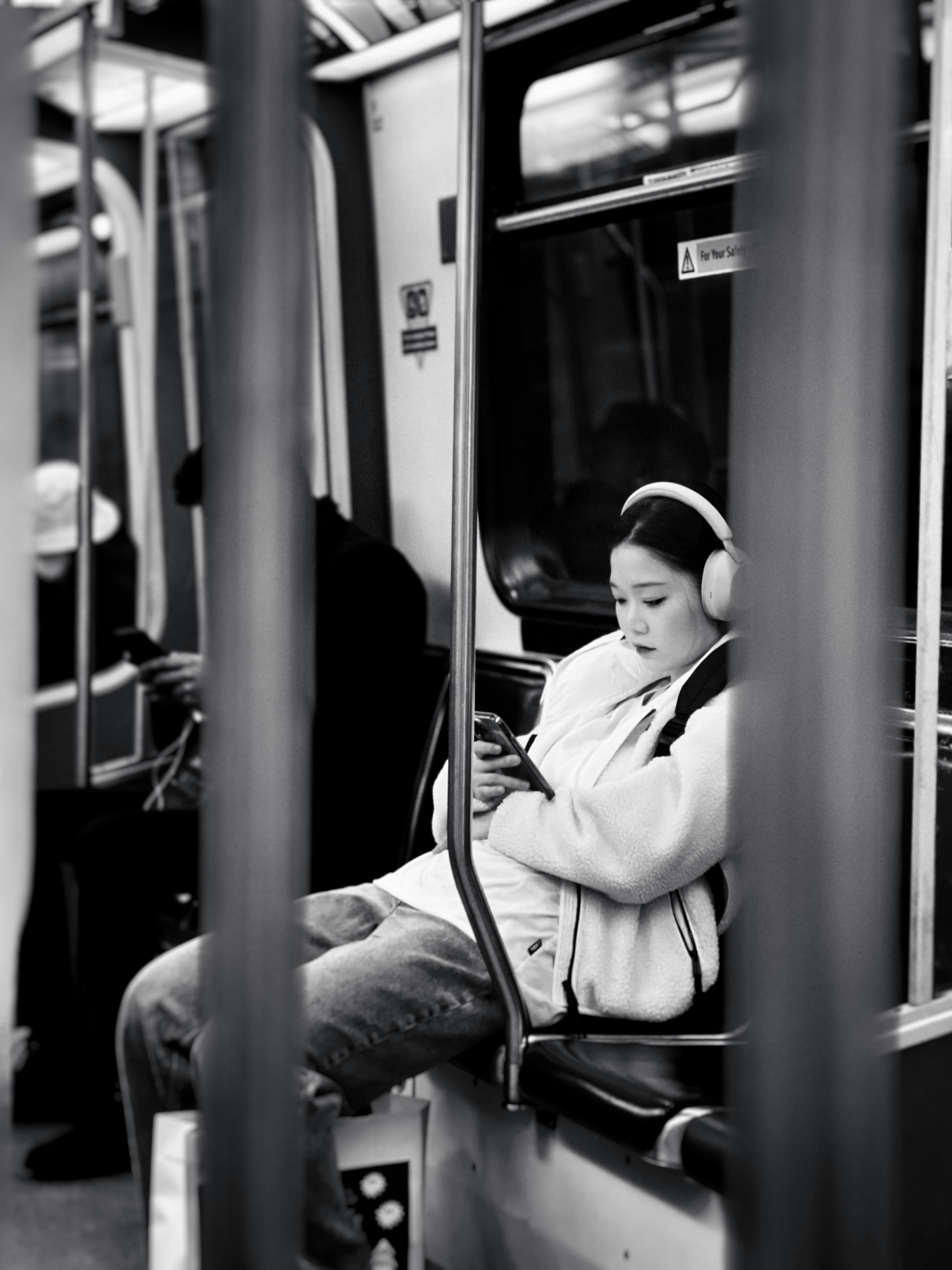 Smiling Woman Sitting on Metro Train in Black and White · Free Stock Photo
