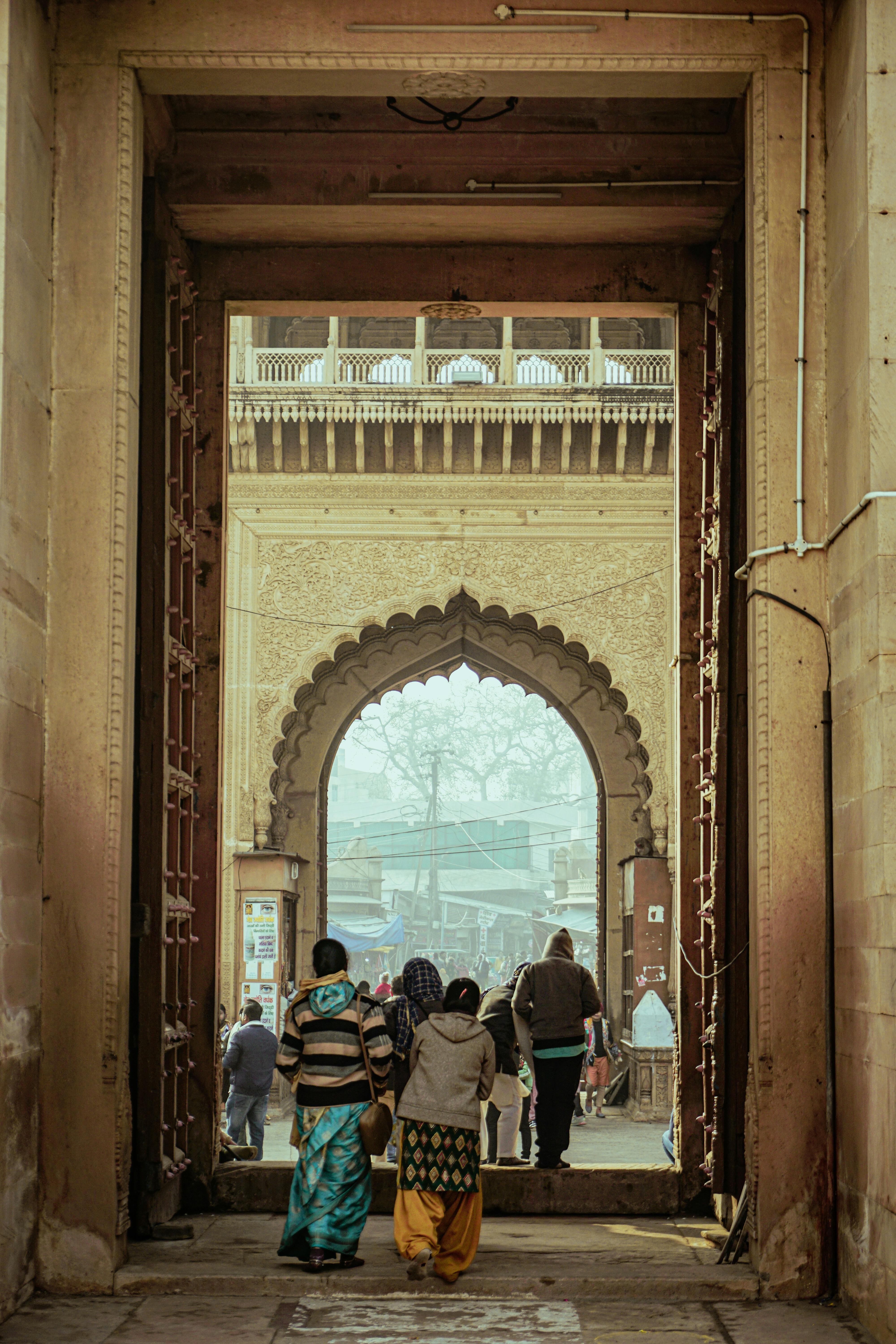 People Walking though an Arched Gate of a Temple · Free Stock Photo