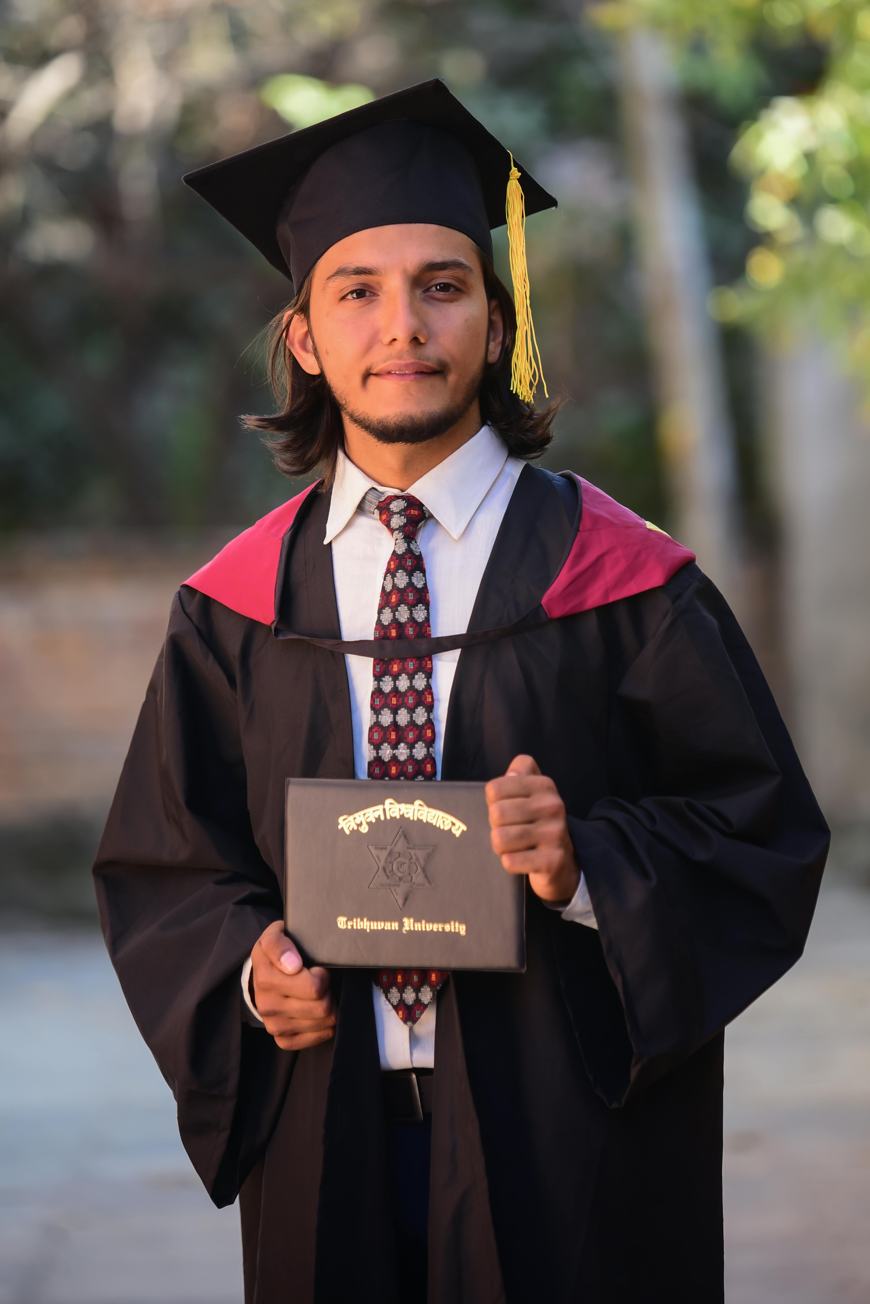 A Person Holding a Black Graduation Hat · Free Stock Photo