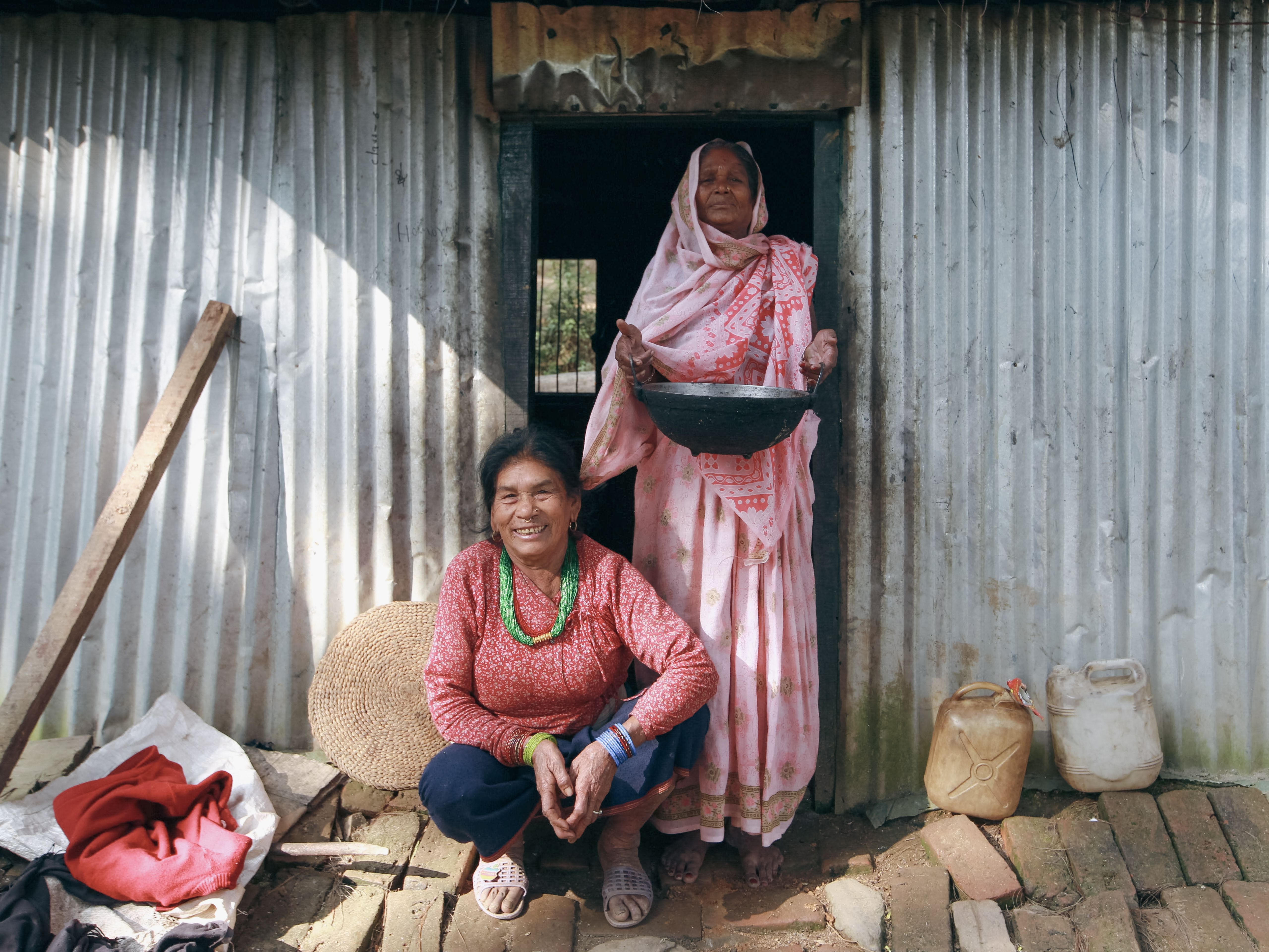 Smiling Women in Traditional Clothing by Shed from Sheet Metal · Free ...