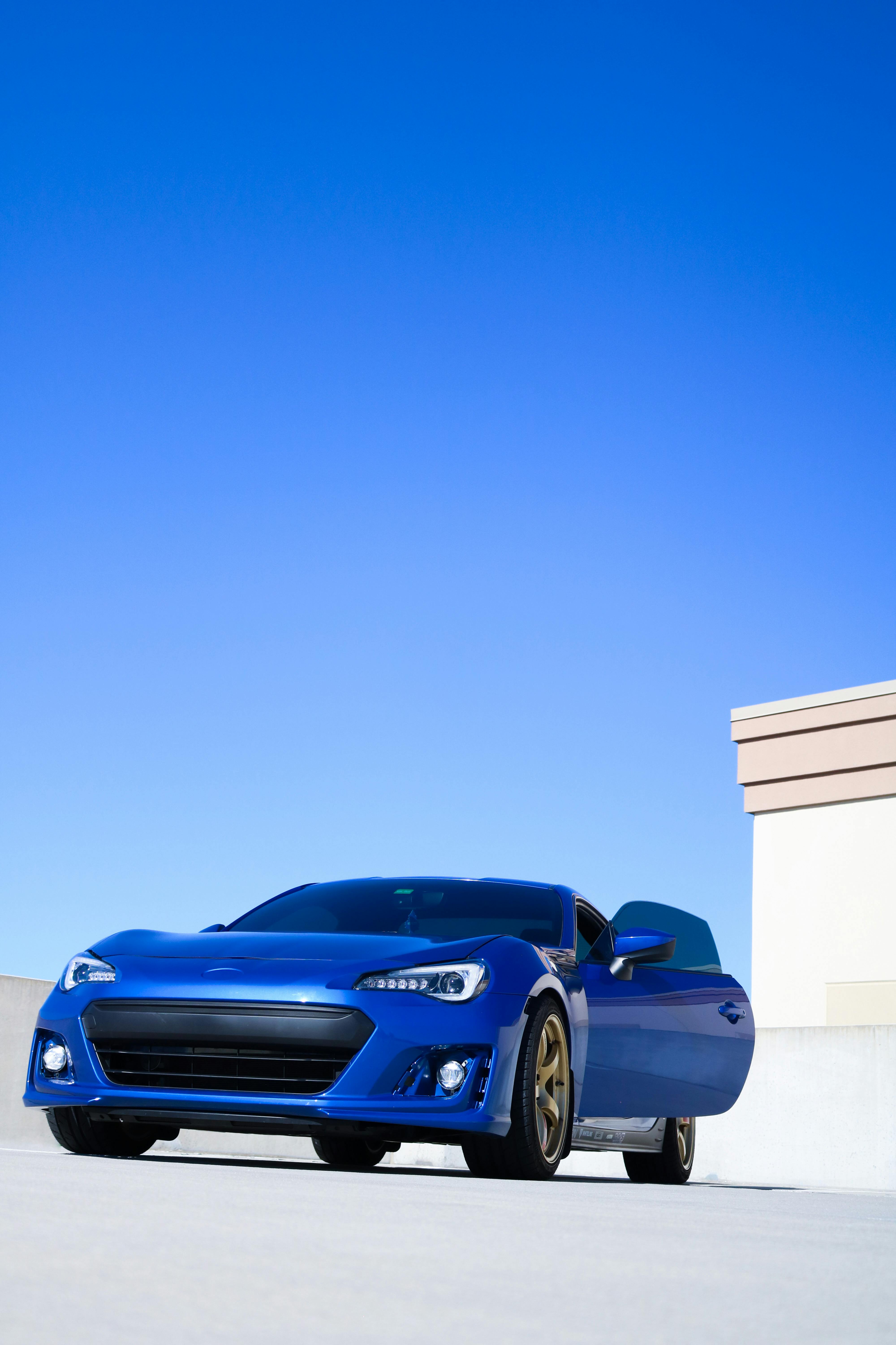 Clear Sky over Blue Sports Car · Free Stock Photo
