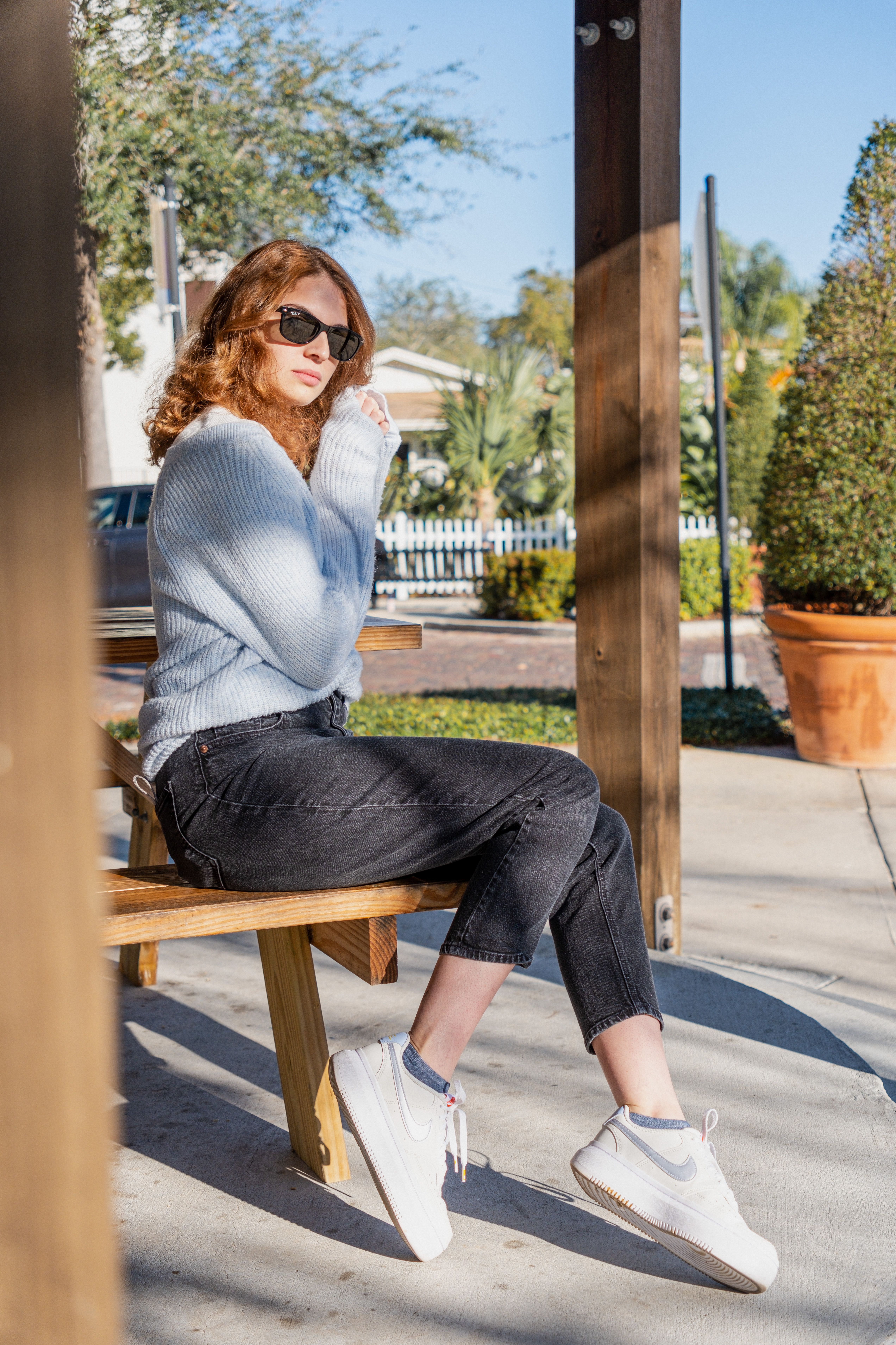 Photo of a Woman in a Sweater Sitting on a Wooden Bench · Free Stock Photo