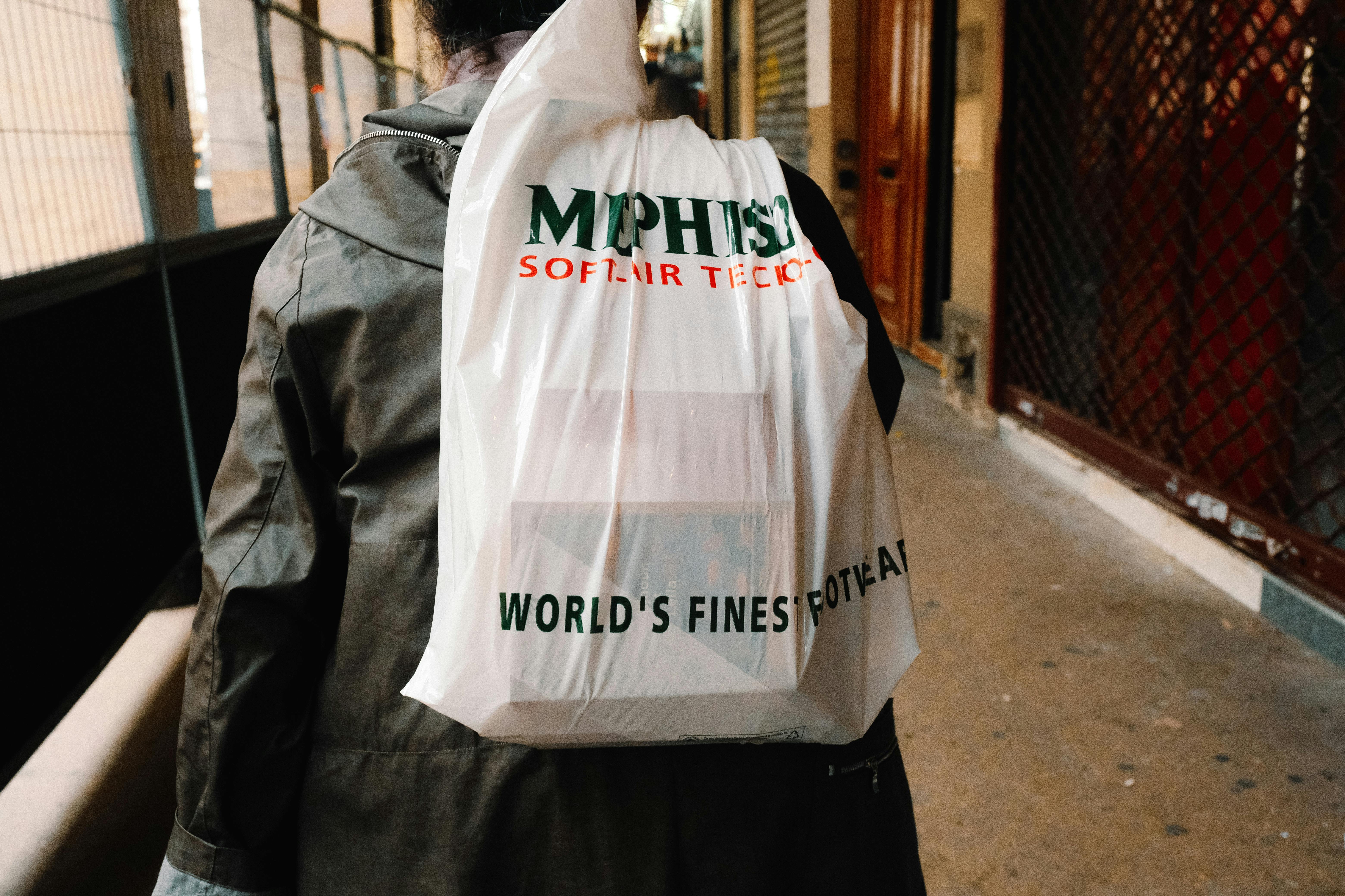 Back View of a Person Carrying a Plastic Bag · Free Stock Photo