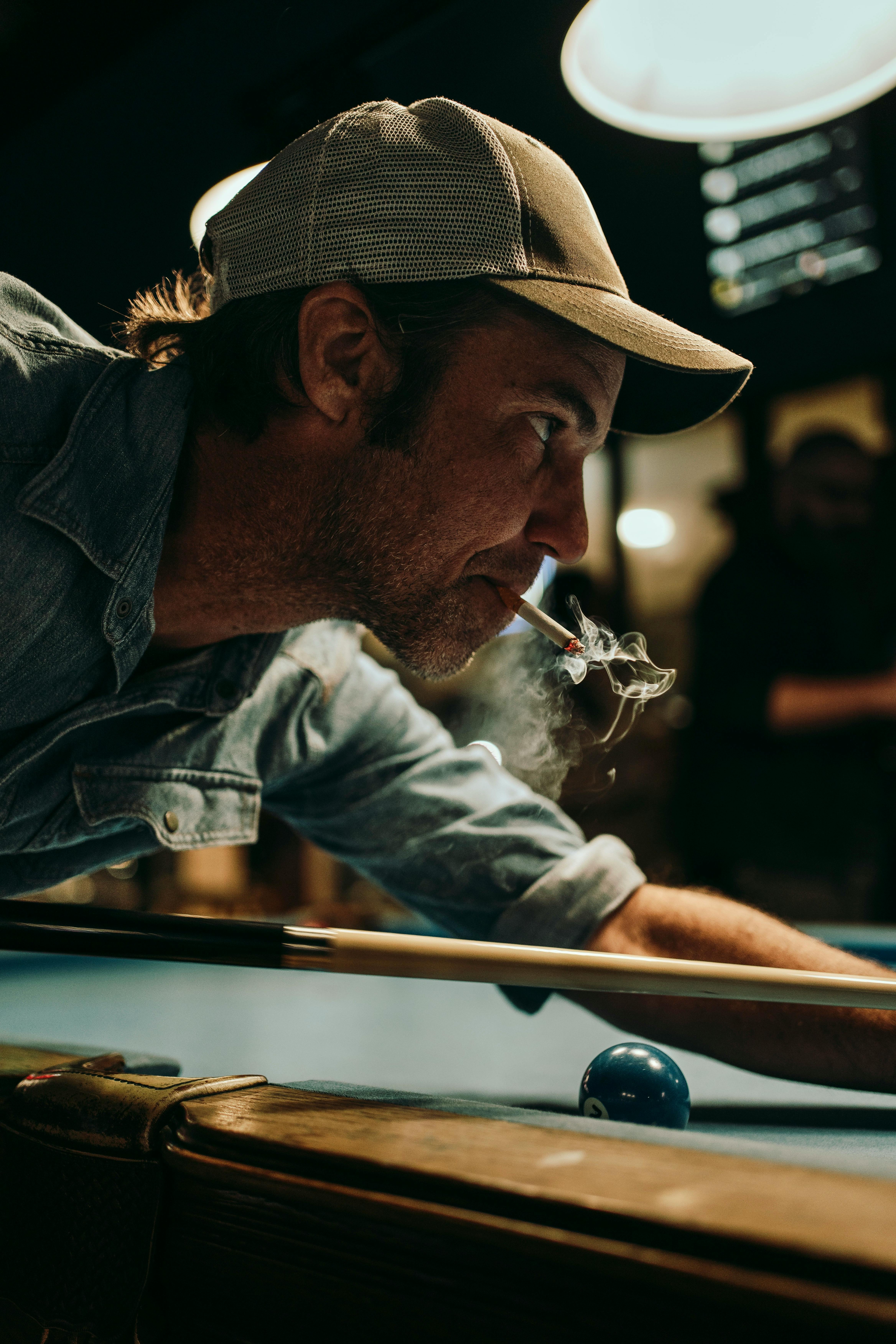 A Man Playing Snooker and Smoking · Free Stock Photo