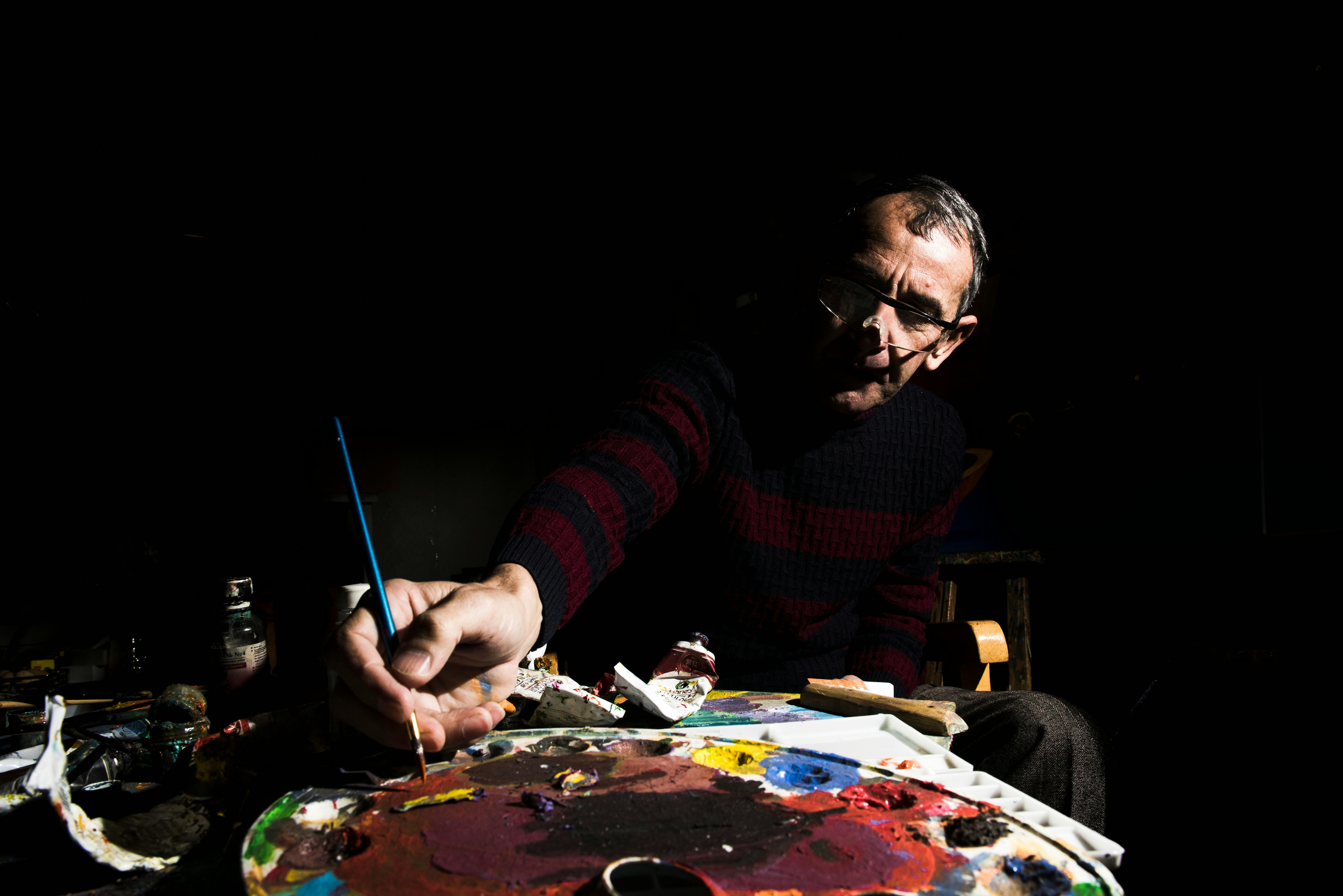 Artist Sitting and Painting · Free Stock Photo