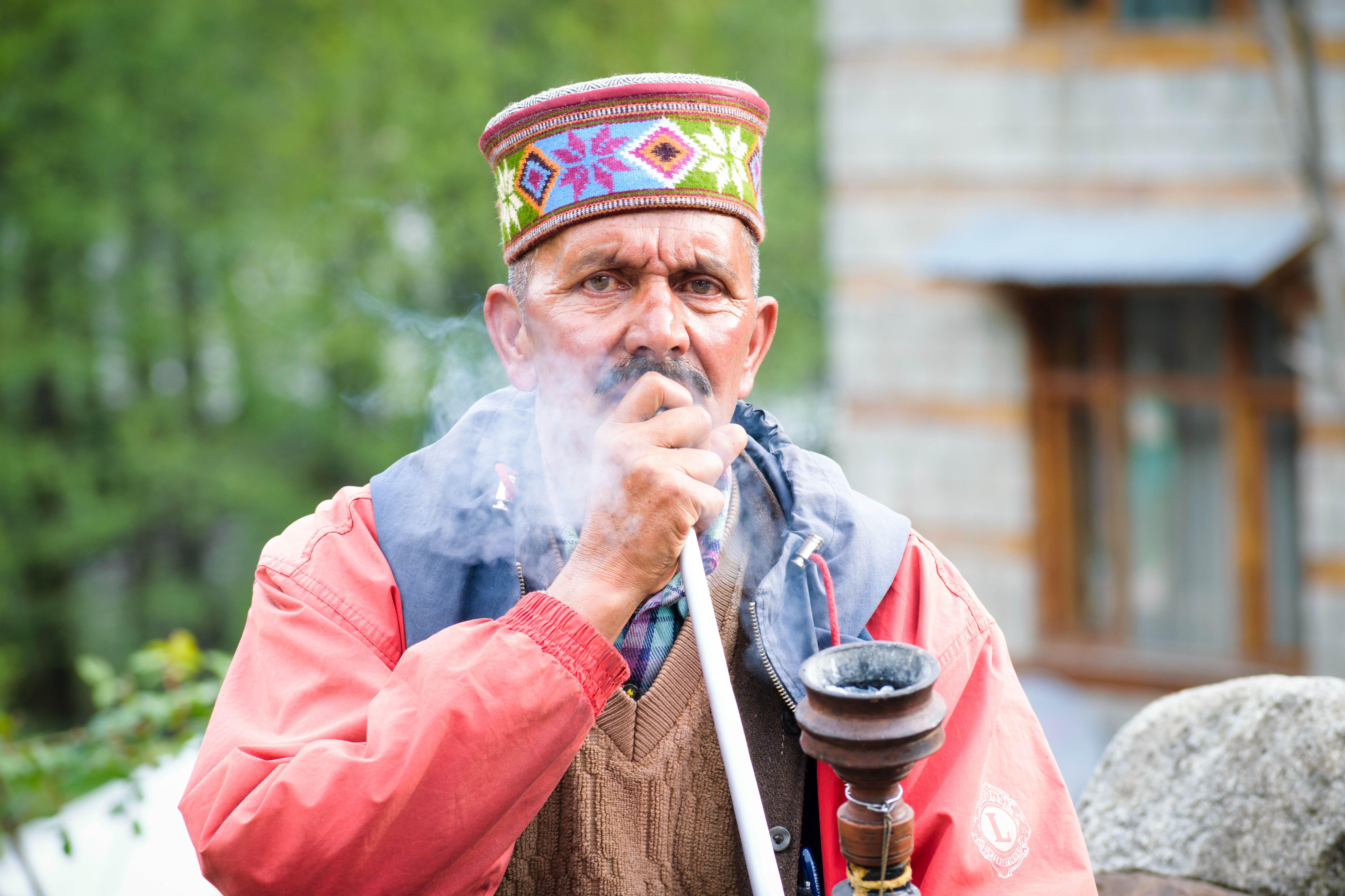 Elderly Man in Traditional Headwear Smoking · Free Stock Photo