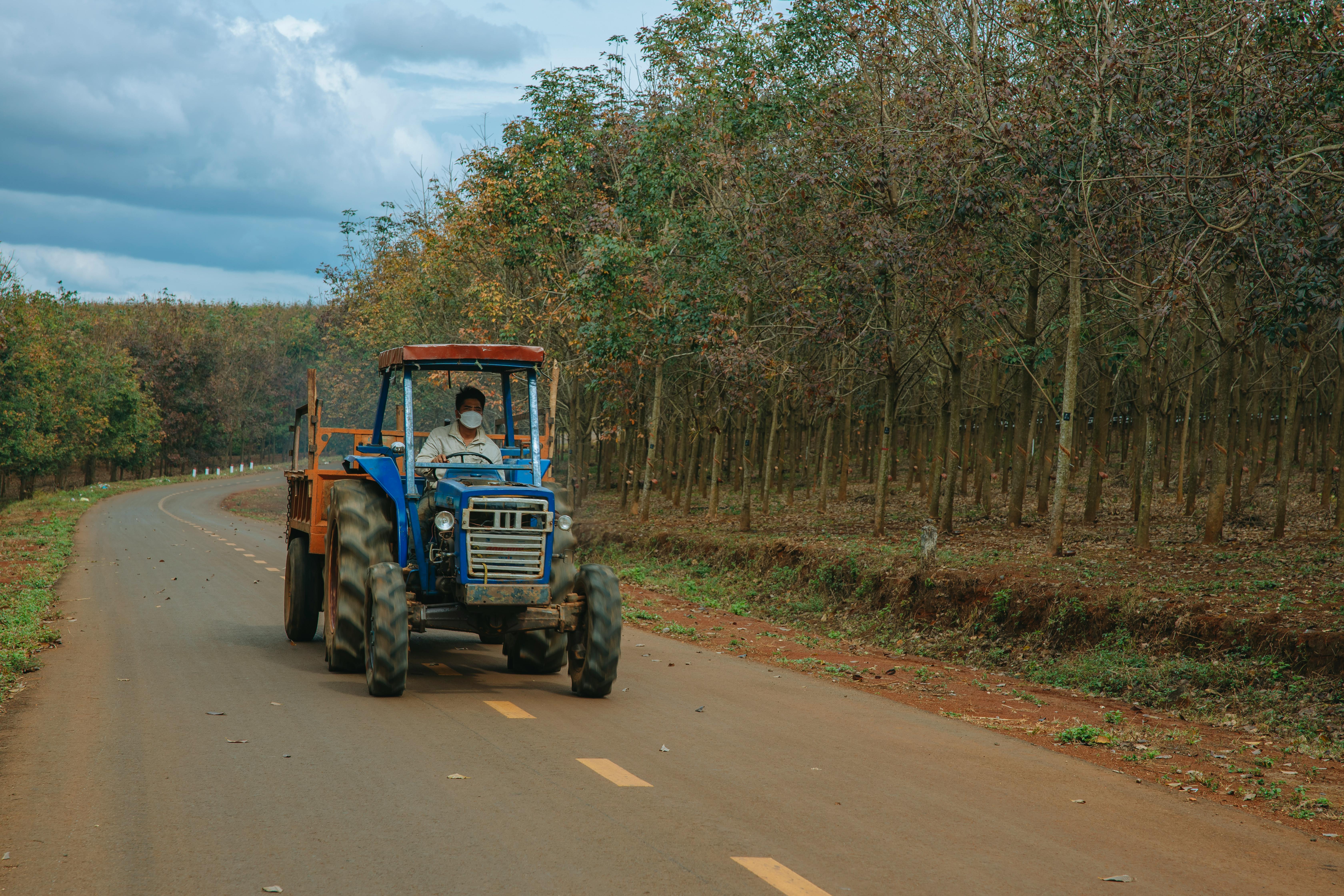Man Driving Tractor on Road · Free Stock Photo