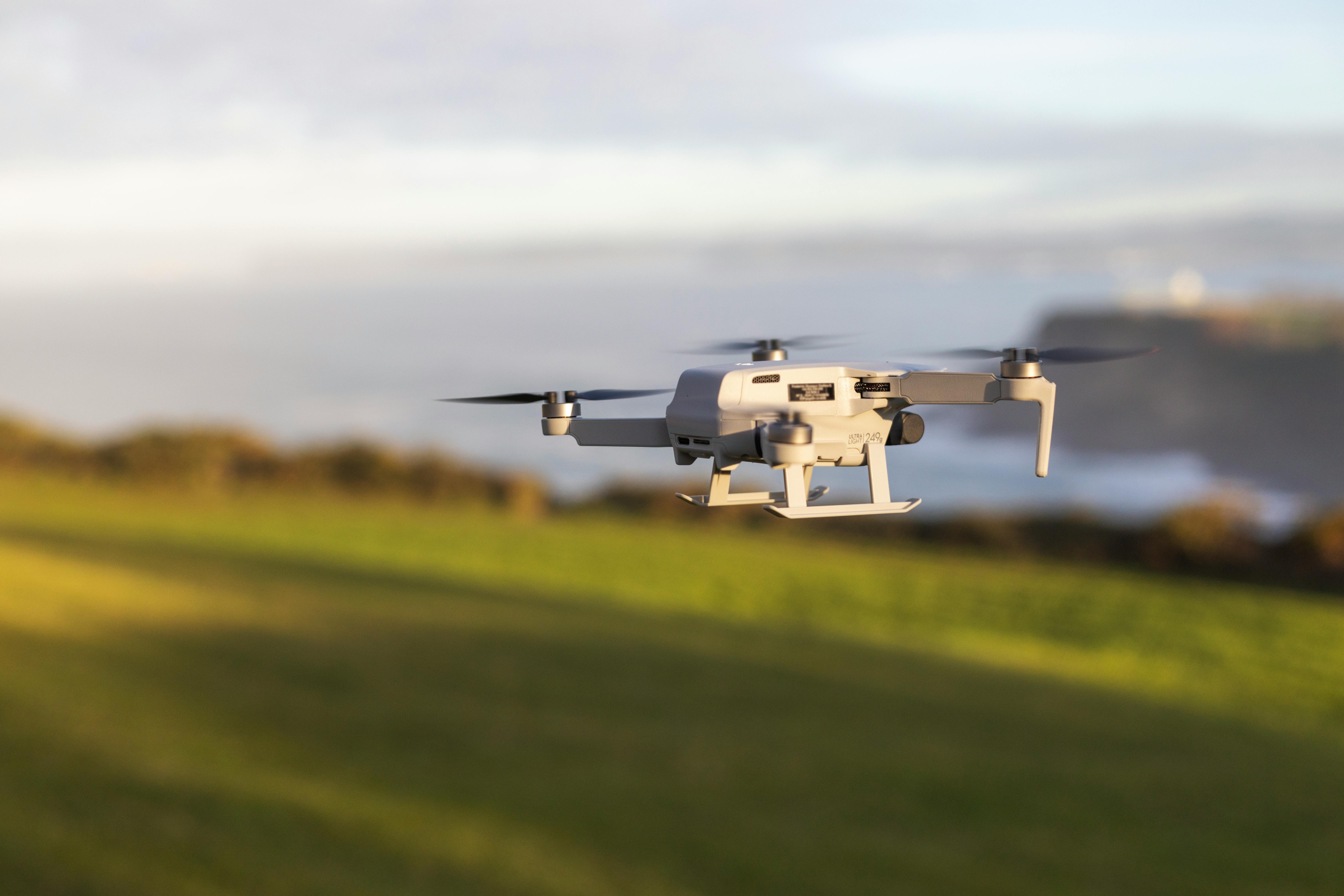White Drone Quad Copter On Grass Field · Free Stock Photo