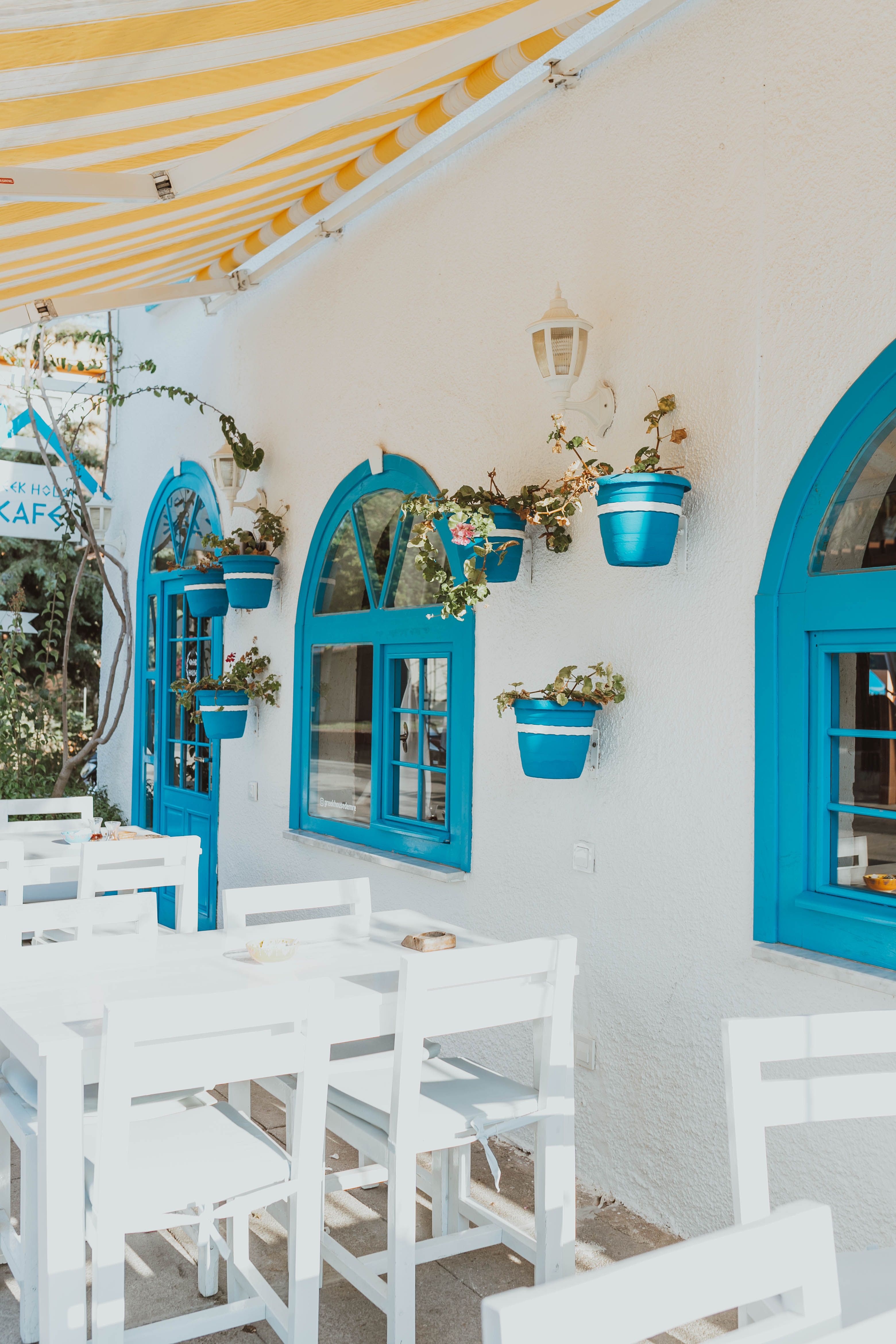 A white and blue restaurant with yellow and blue striped awnings · Free ...