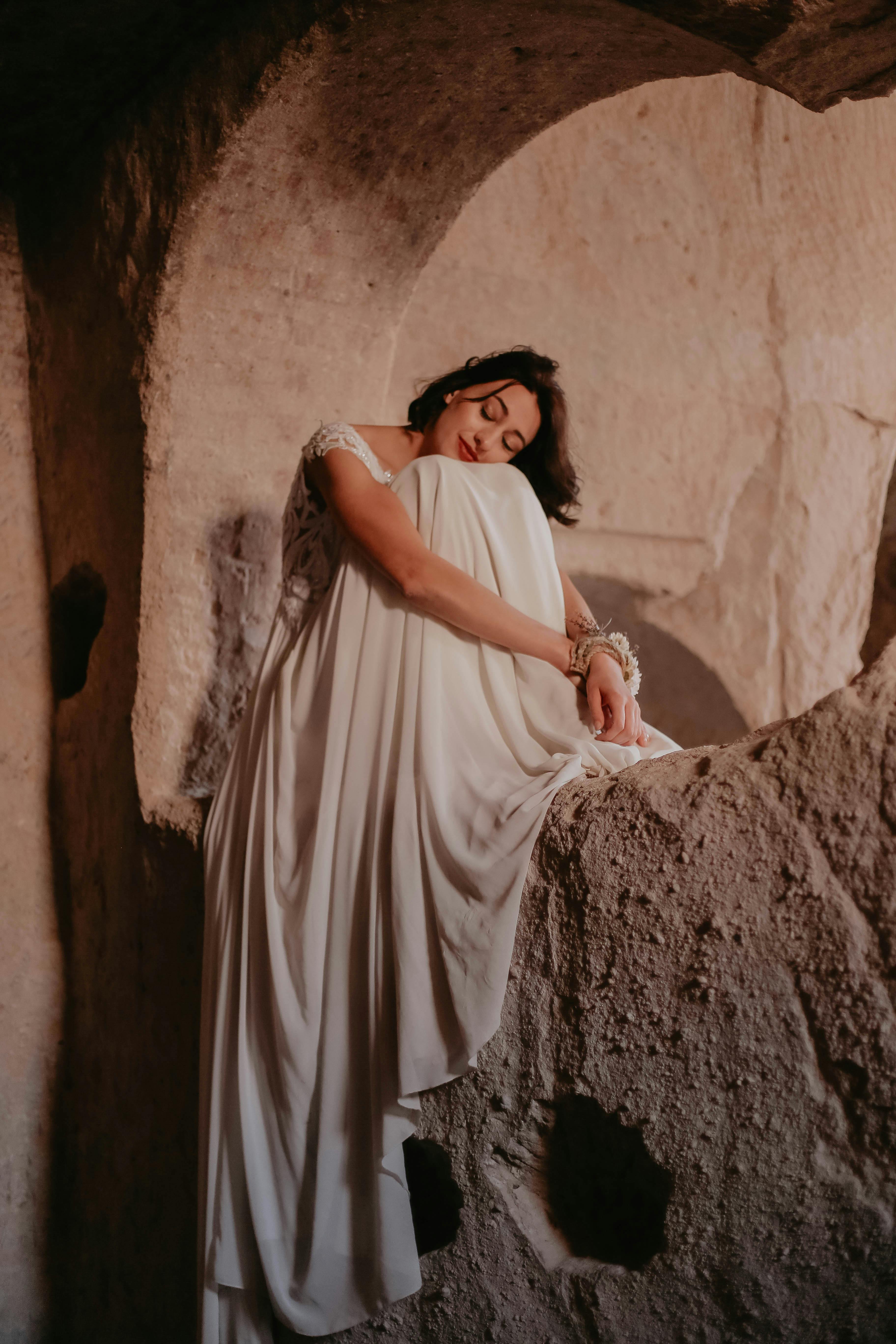 Model in a Long White Evening Dress Sitting in a Rock-cut Window · Free ...