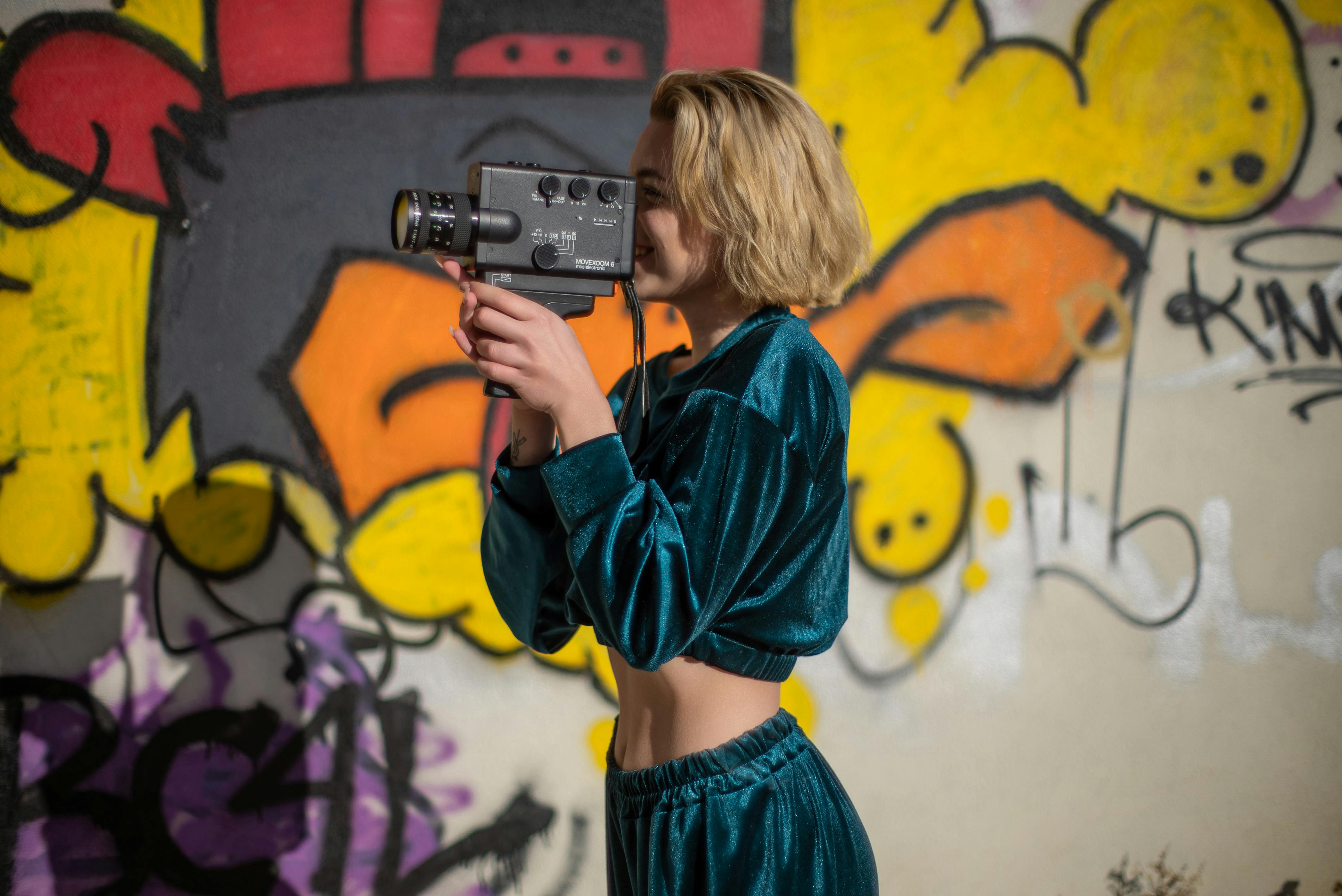 Woman in Green Crop Top Holding a Video Camera · Free Stock Photo