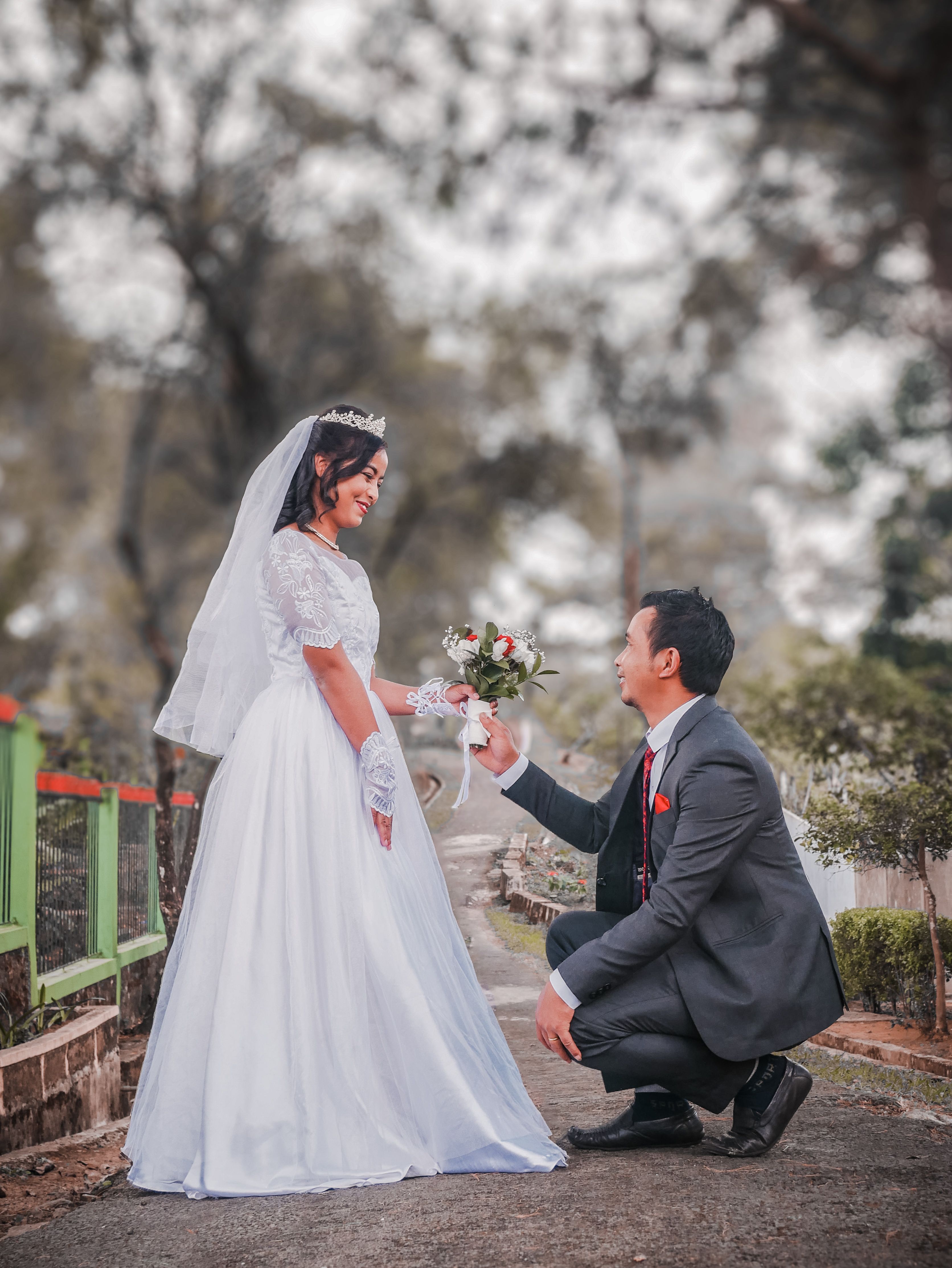 Bridegroom Kneeling before a Bride with a Bouquet of Flowers · Free ...