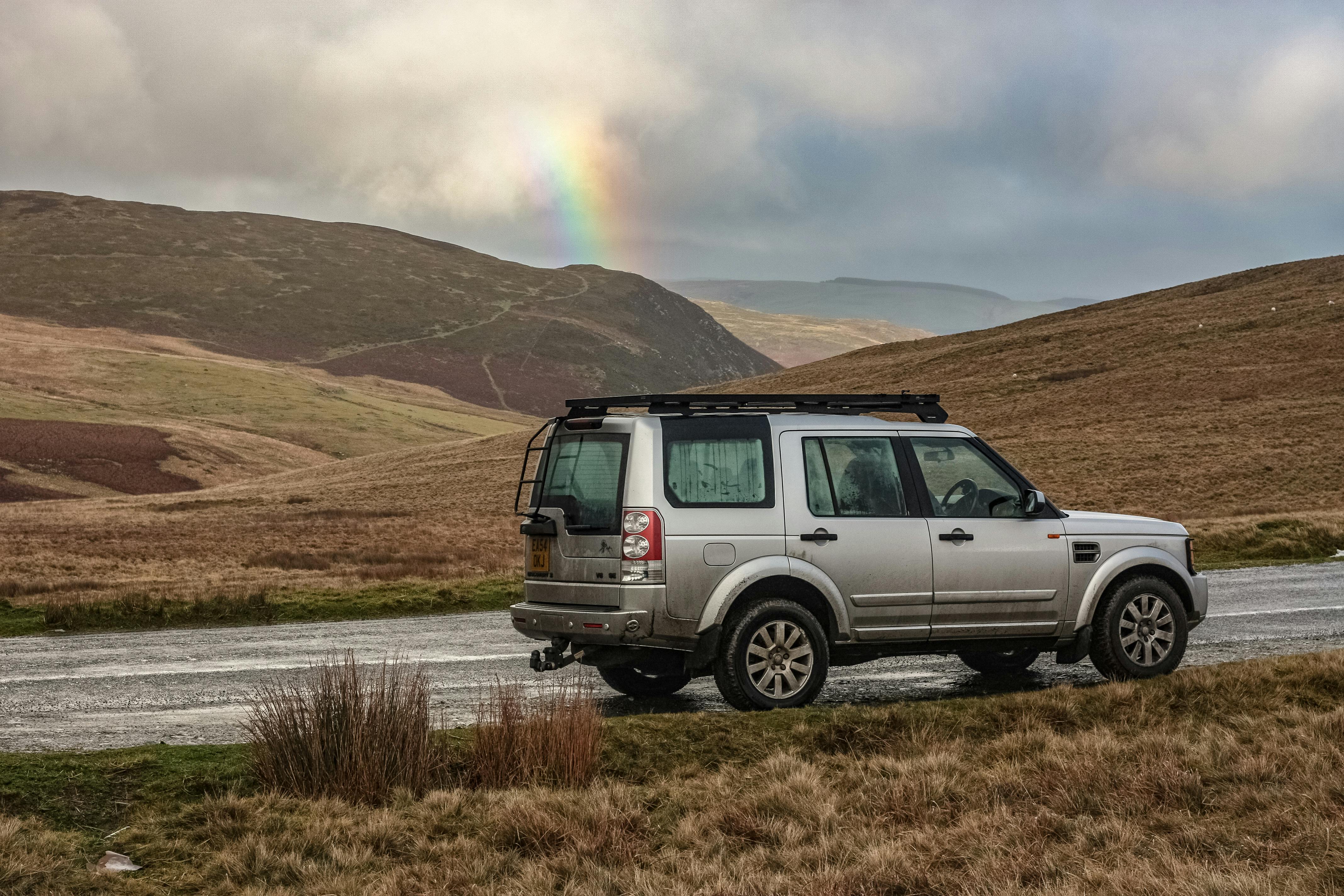 Land Rover Parked on Roadside under Rainbow · Free Stock Photo