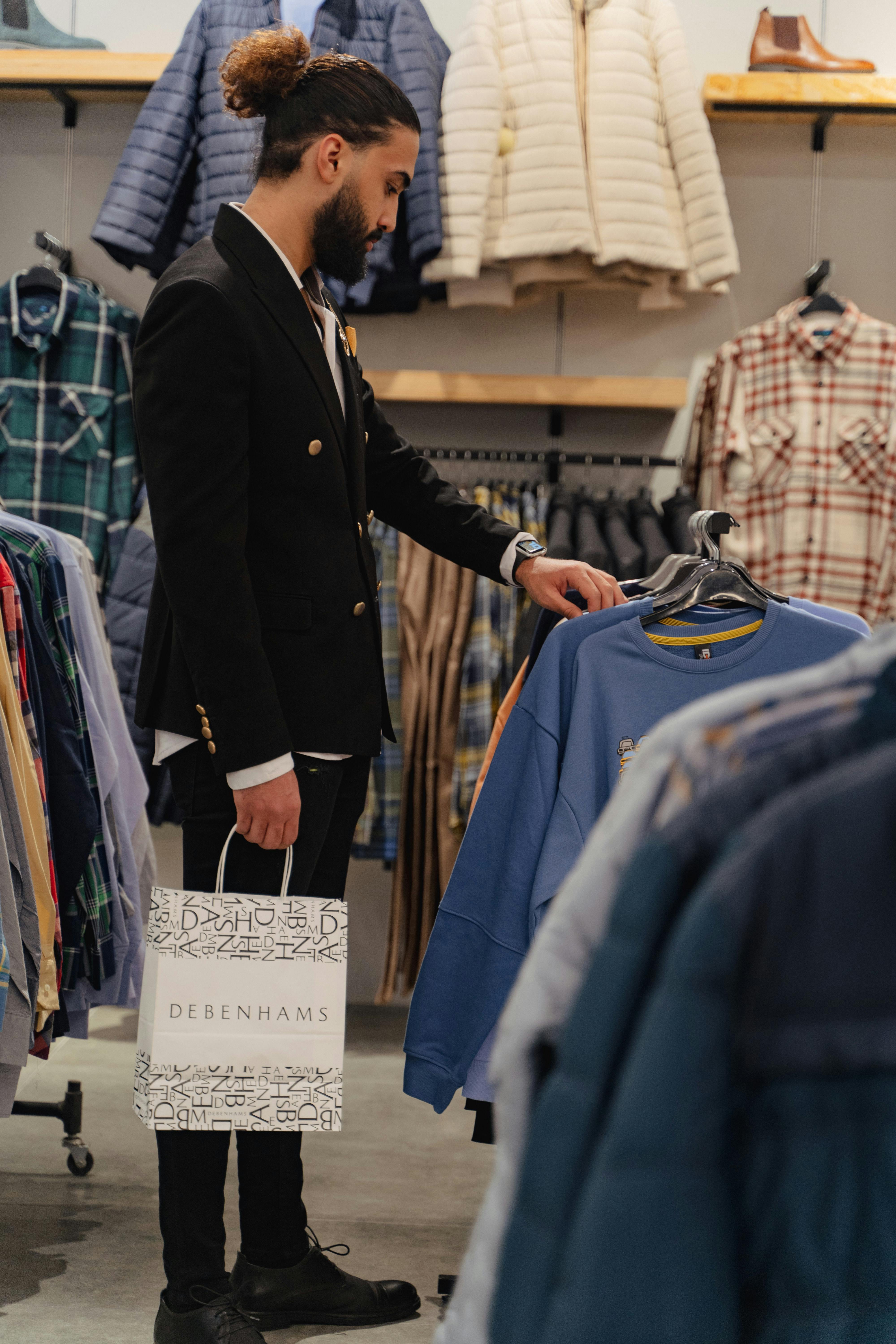 A man in a store looking at clothes · Free Stock Photo