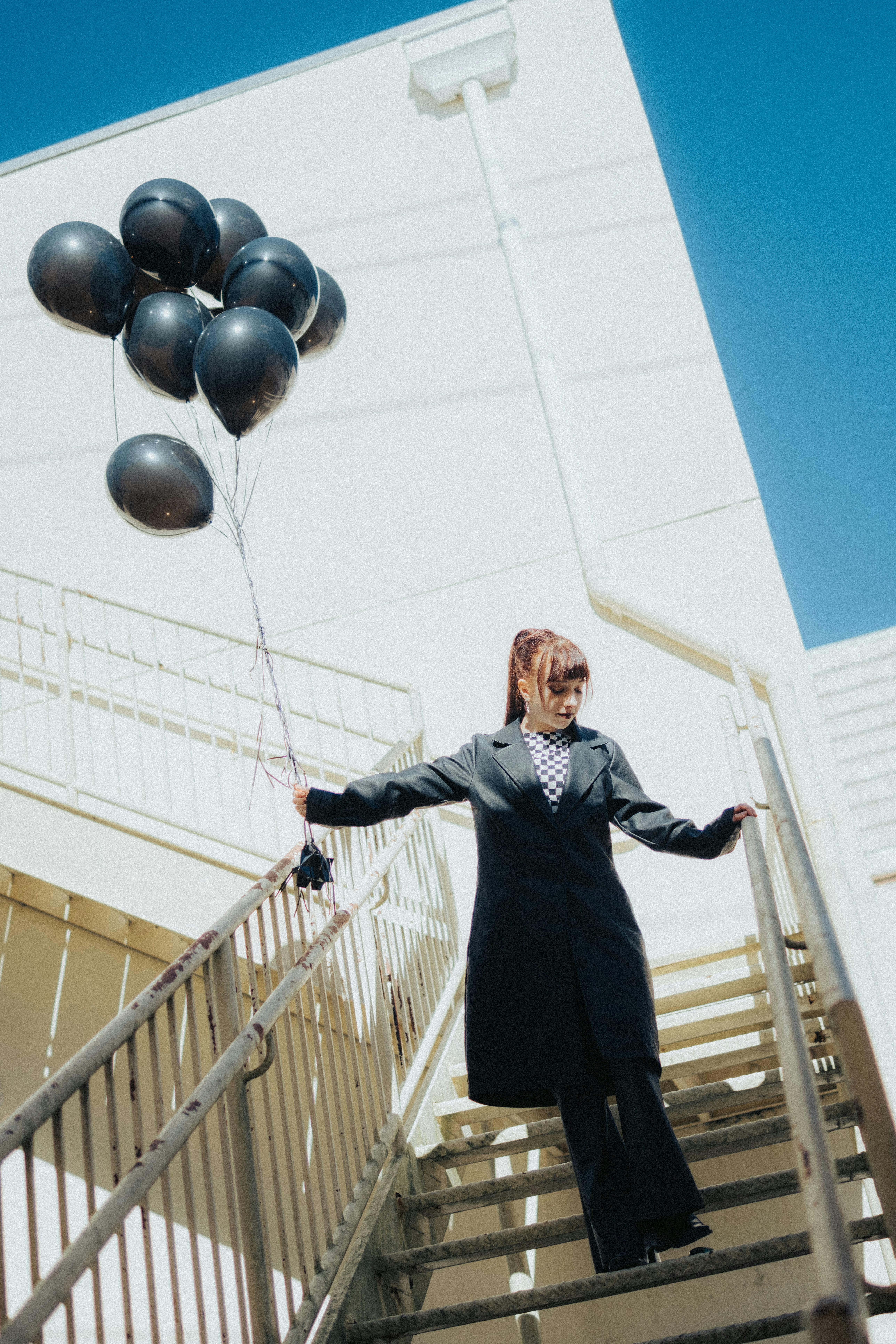 Woman Holding Balloons on Steps · Free Stock Photo