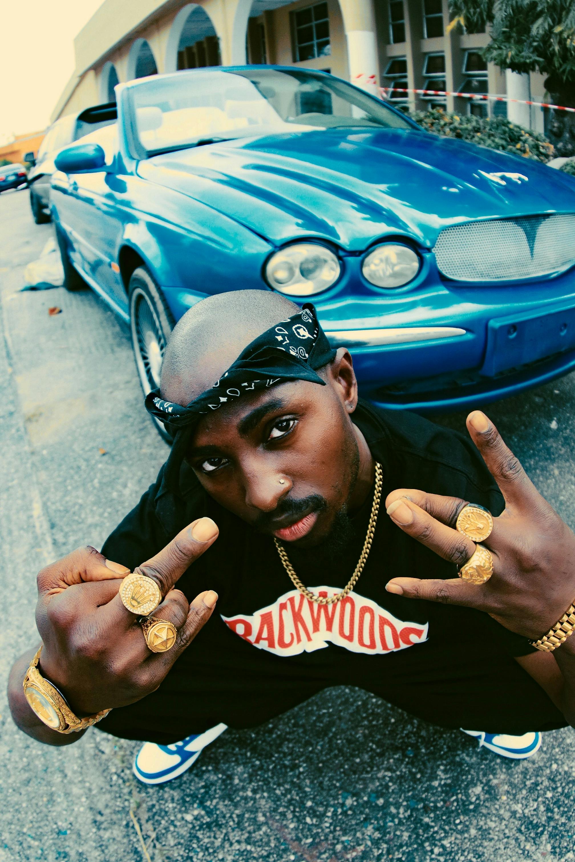 Rapper Posing near Blue Car · Free Stock Photo