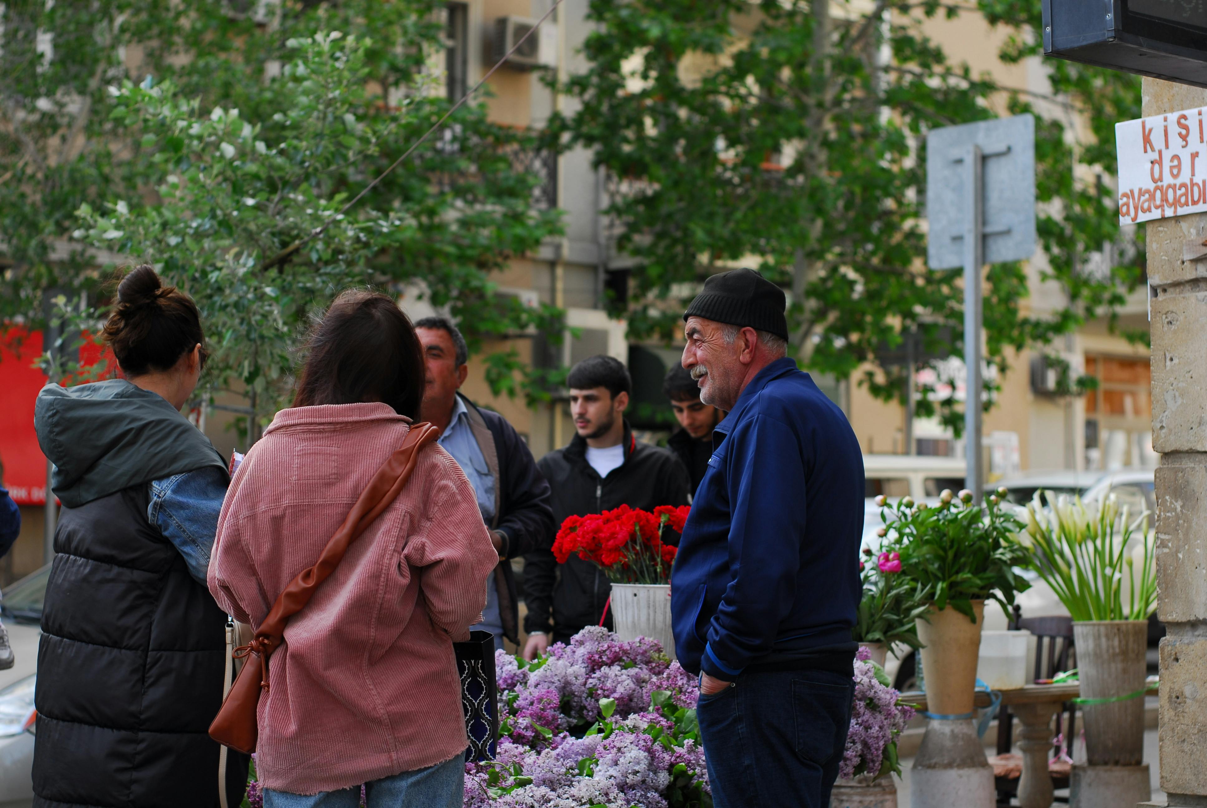 Man Selling Flowers on Sidewalk · Free Stock Photo