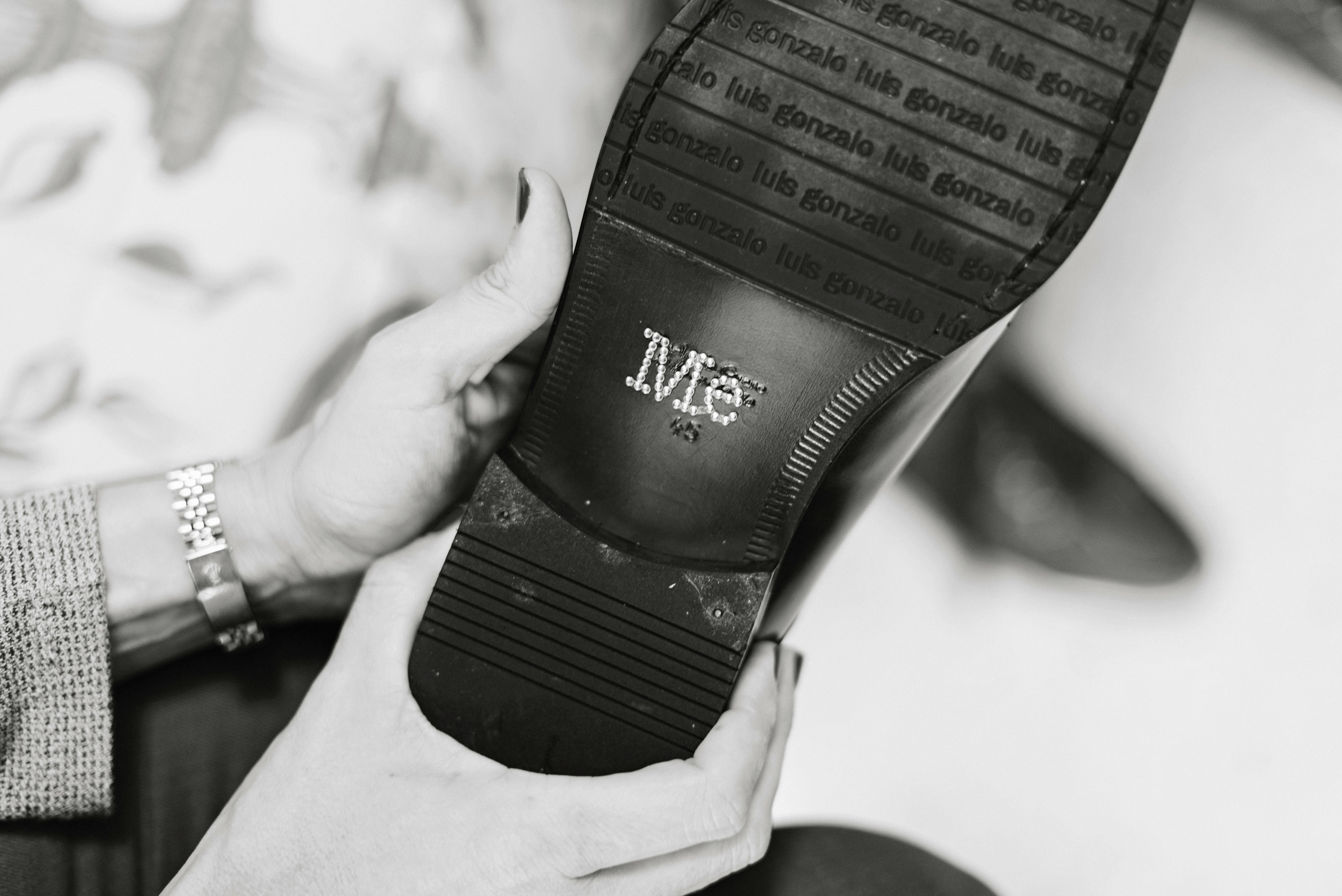 Woman Hands Holding Shoes with Text on Shoe Sole · Free Stock Photo