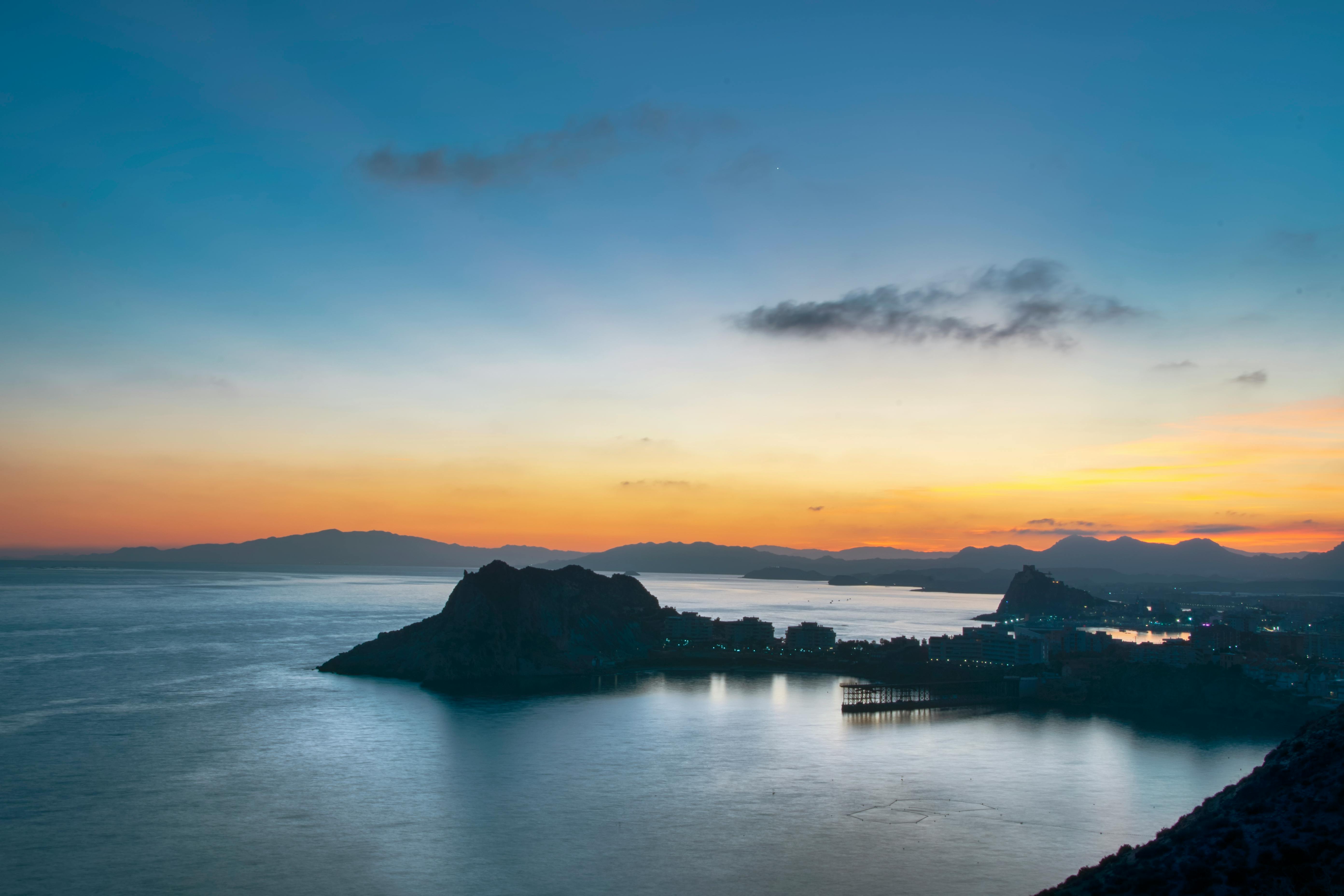 Rocks on Sea Shore in Town at Sunset · Free Stock Photo